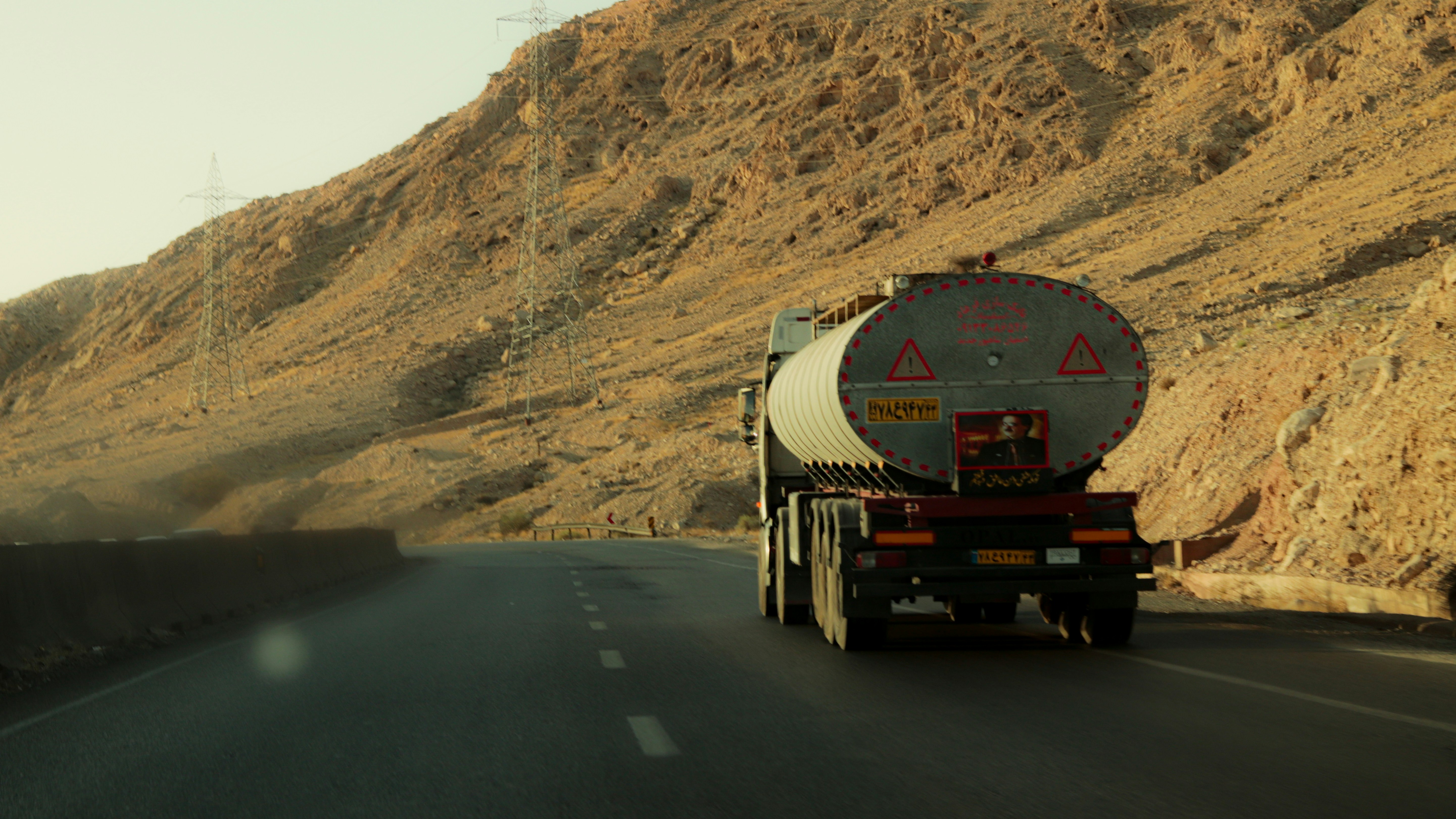 Desert Highway Hauler: A Lone Tanker Traverses a Winding Arid Route