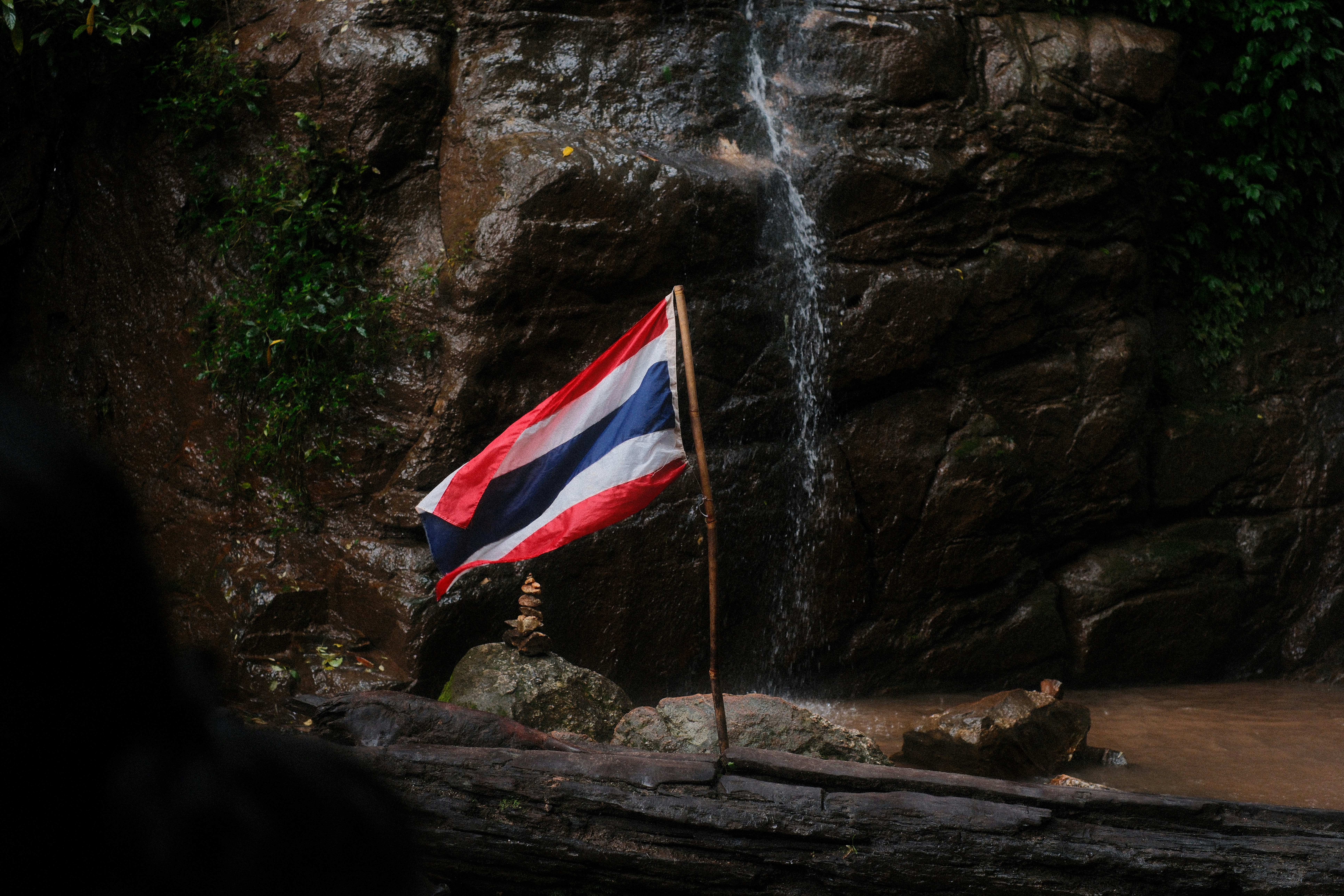 Flag on a Quiet Shore: Thailand’s Cliffside Flag by Faint Cascade