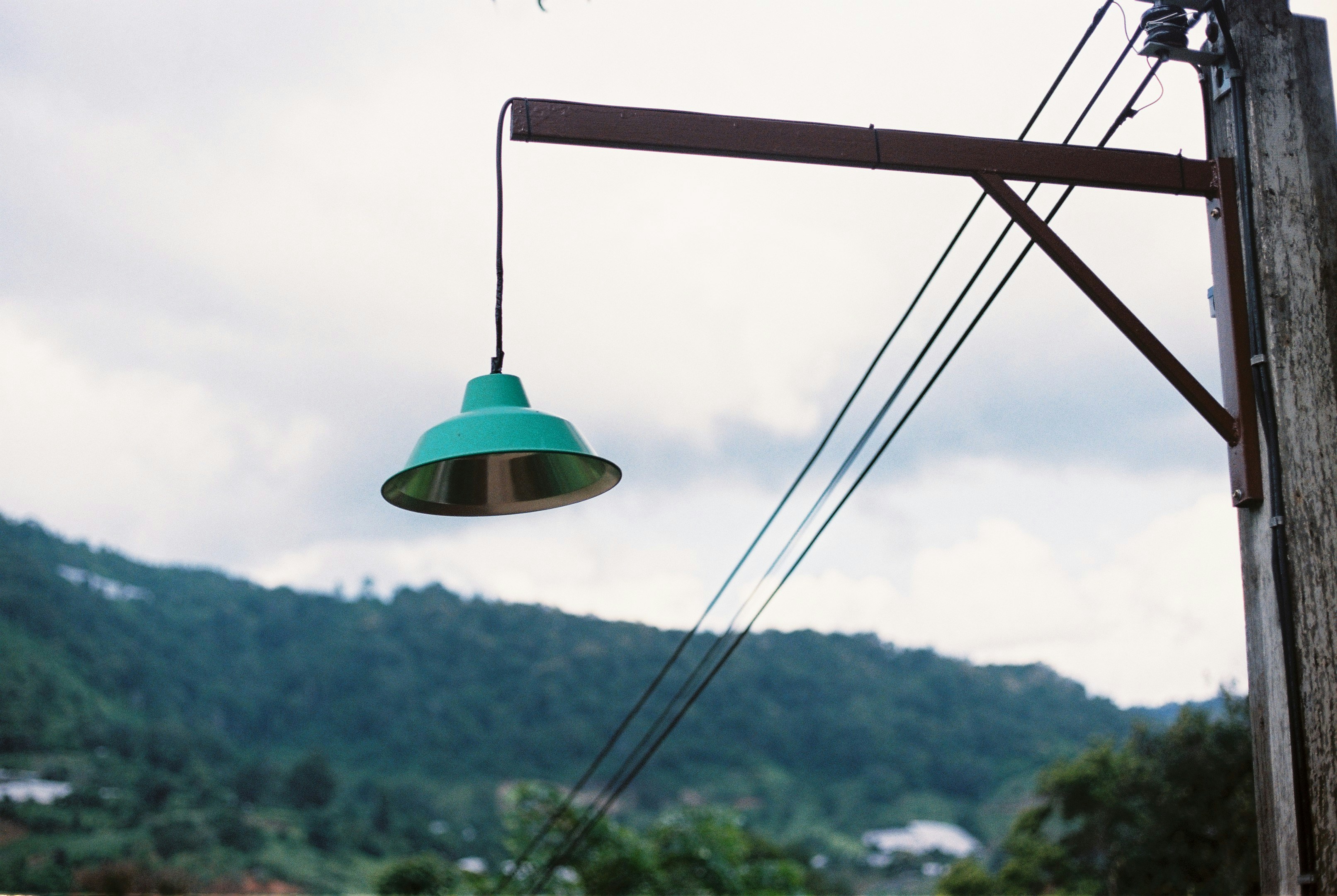 Teal Pendant Light Wlares Over a Green Valley