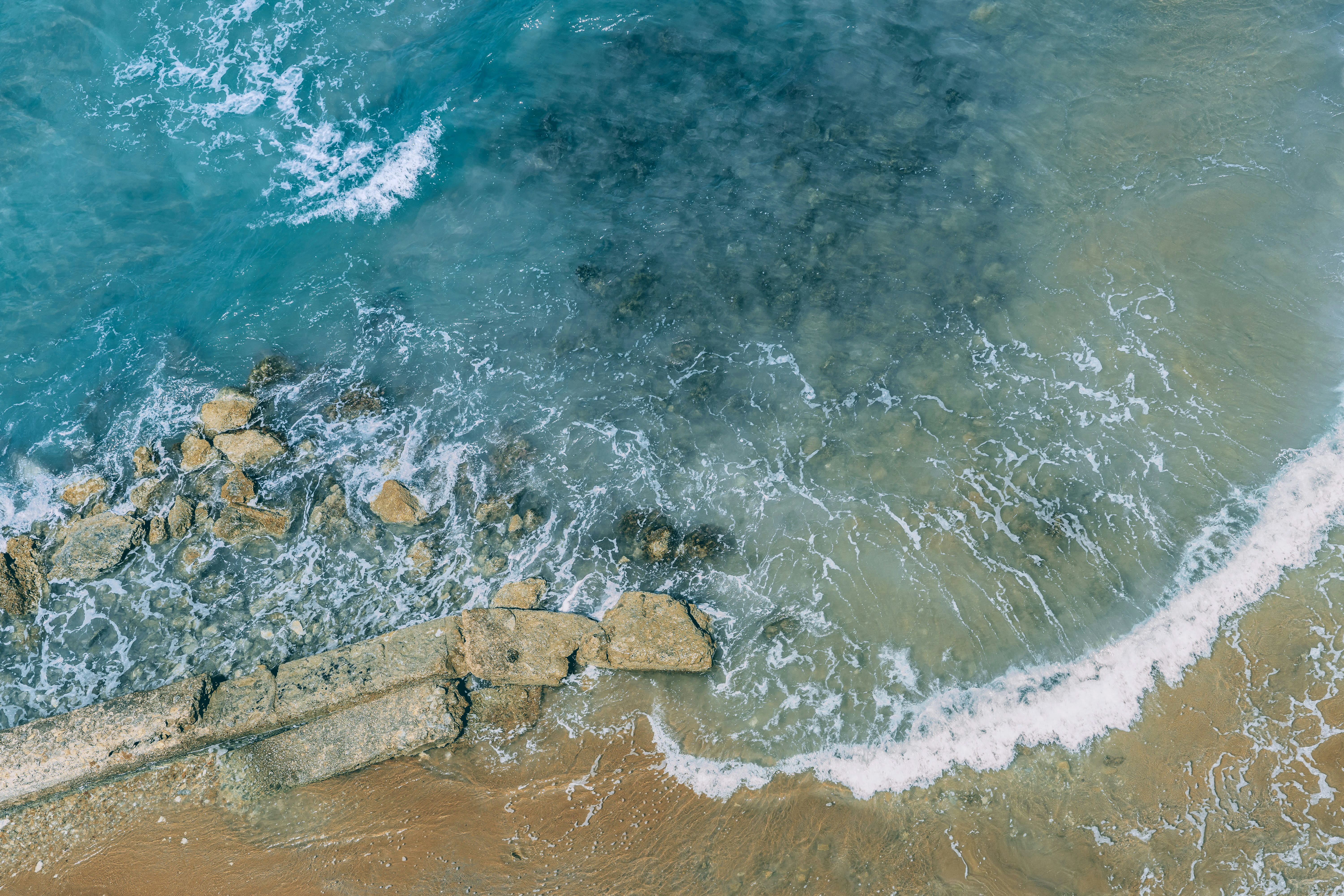 Aerial Tidal Sketch: Rocks Meet Shoreline in Turquoise Cadence
