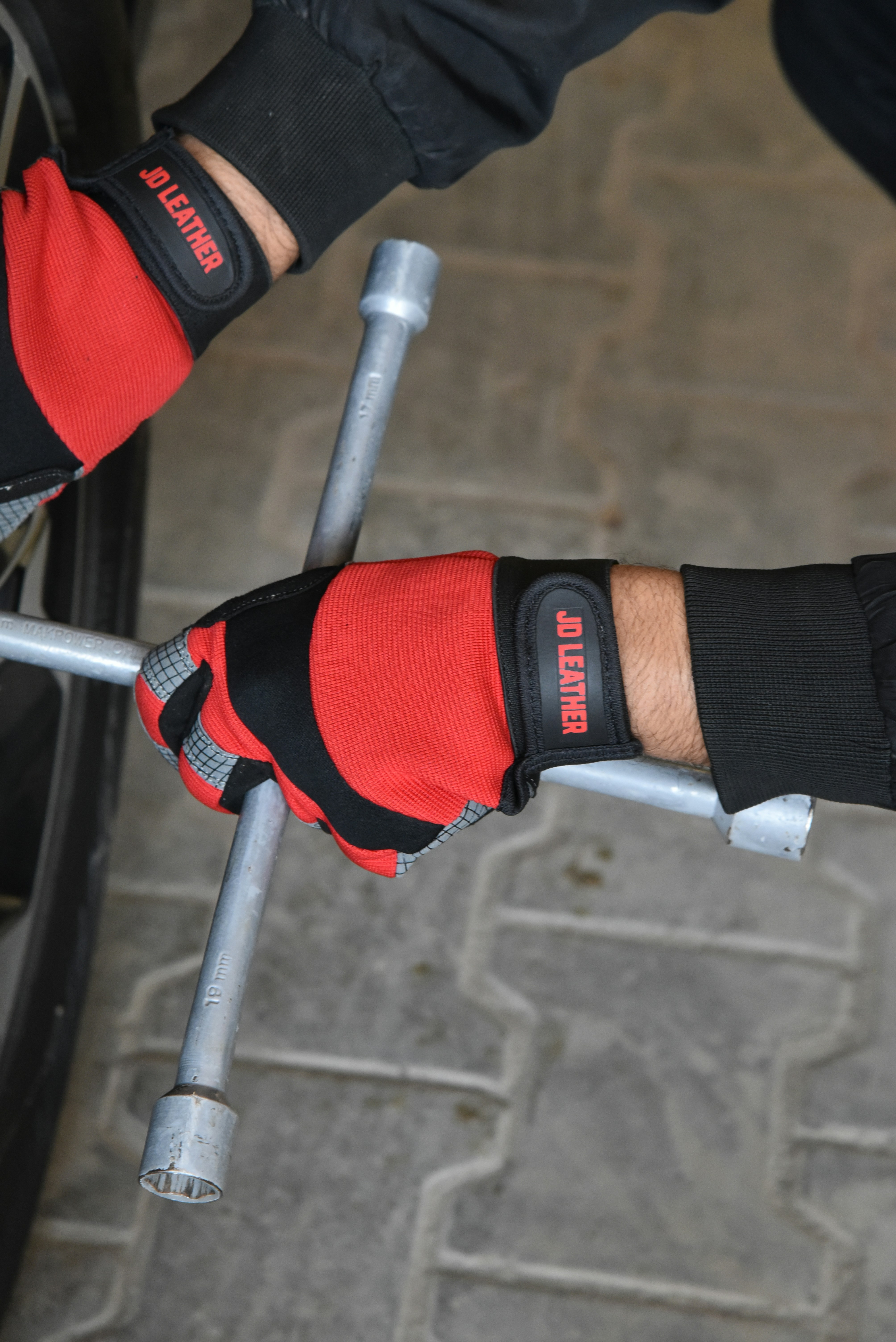 Two gloved hands grip a scaffold crossbar in a hands-on workshop.