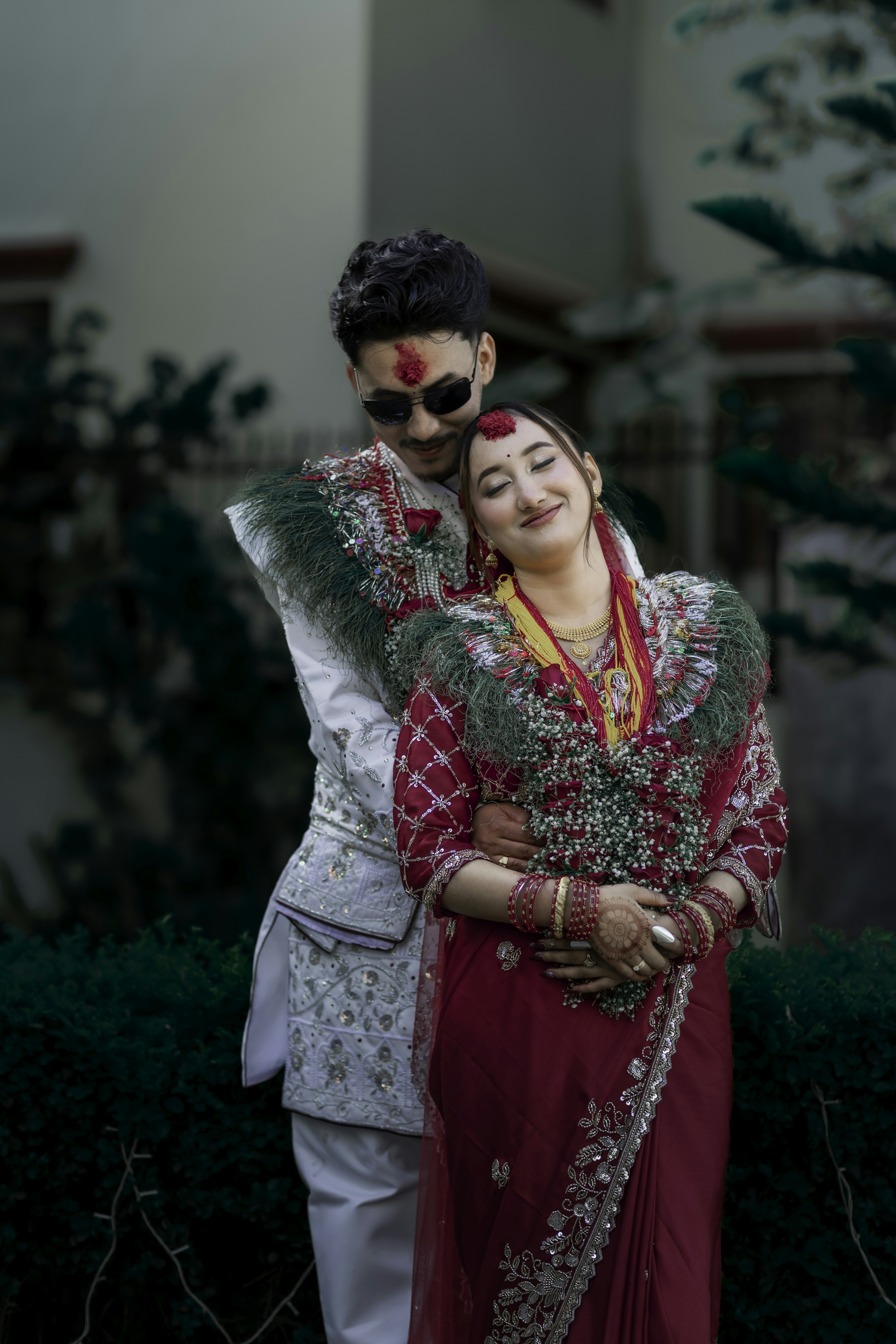Embrace beneath festive petals: a couple in bridal glow