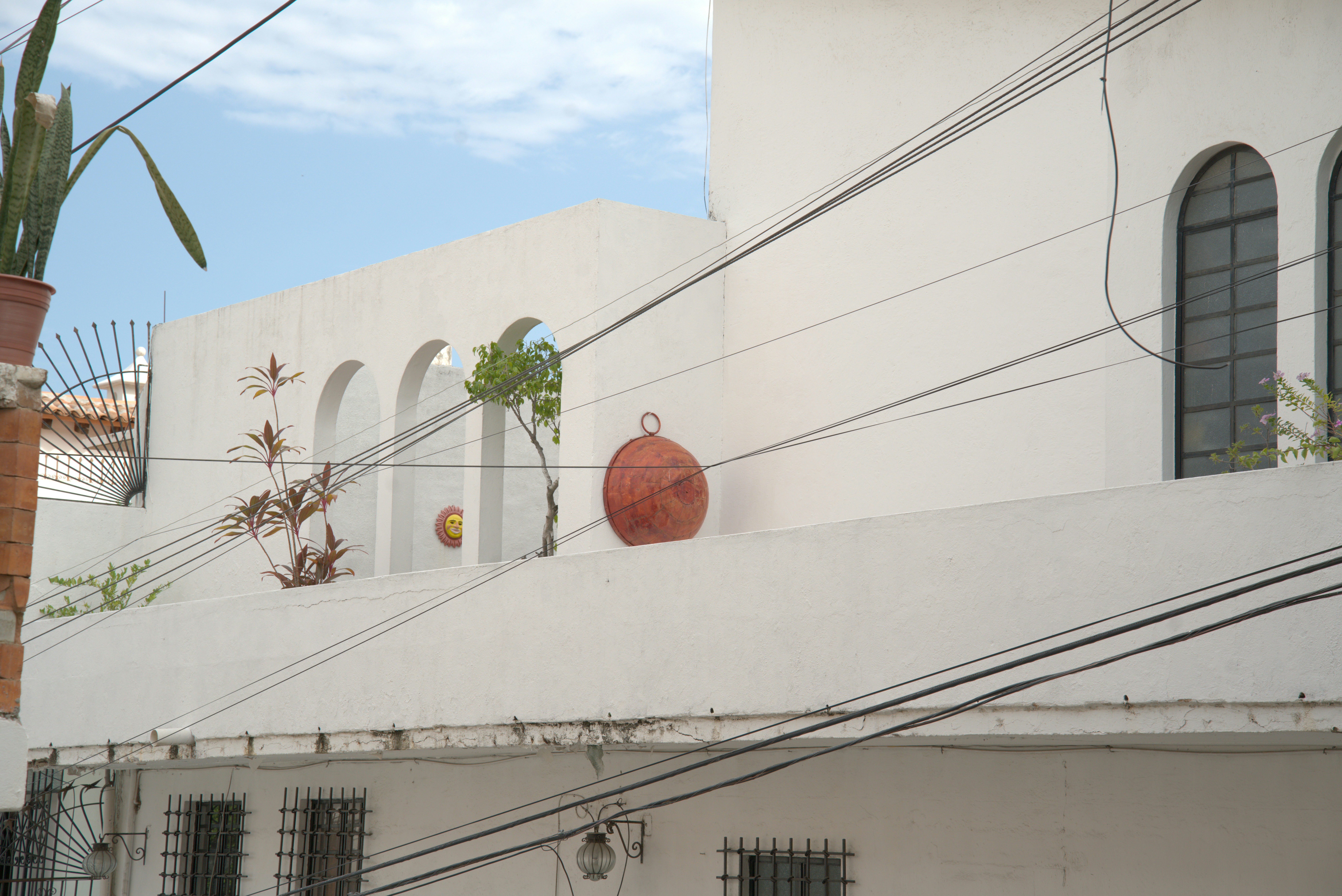 Terraced White Facade with Solar Lines and Red Vessel