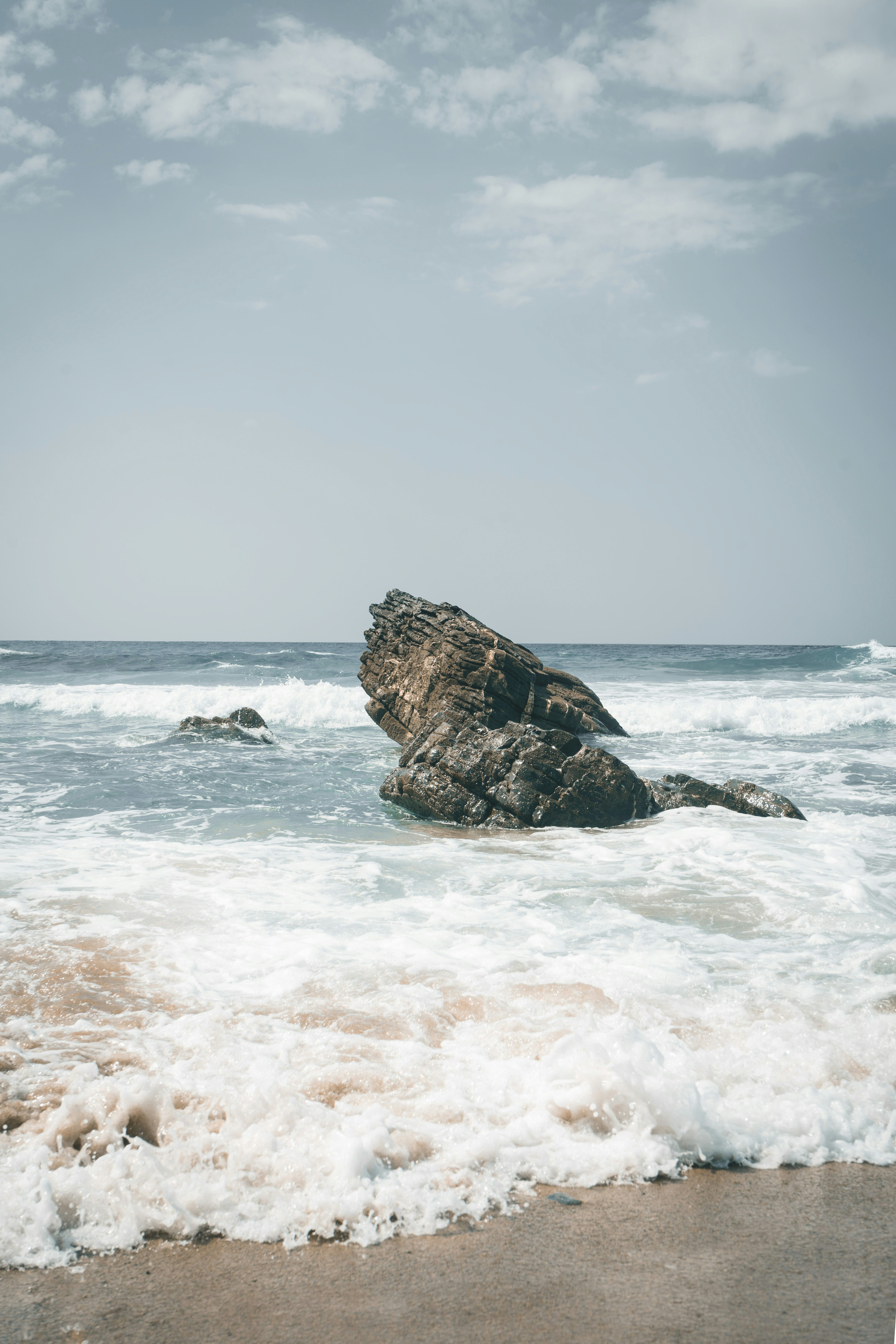 Rock Sentinel in the Tide: A Lone Breaker Rising from the Shore