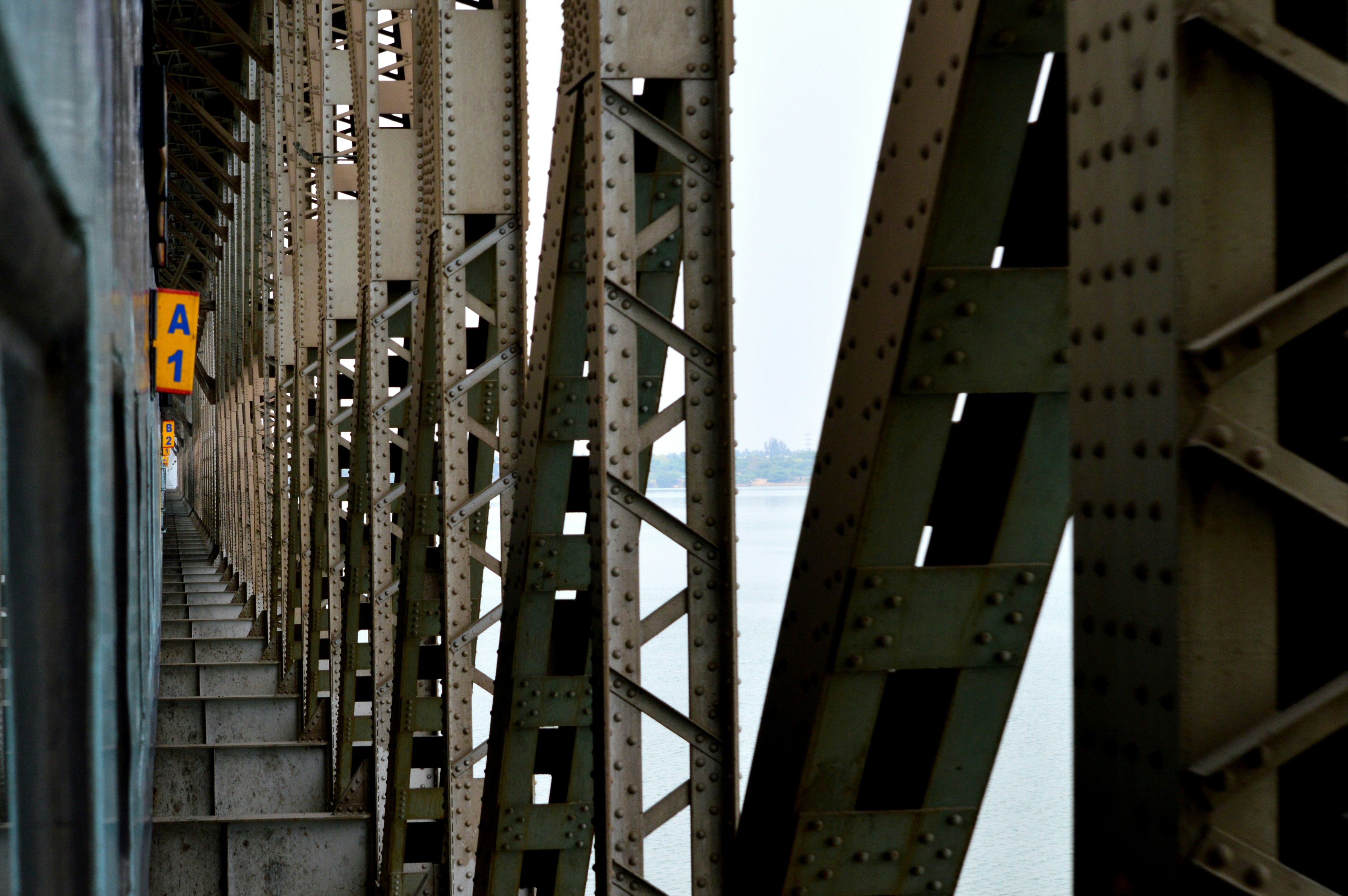 Industrial Lattice Alley: Receding Truss Lines Between Water and Sky