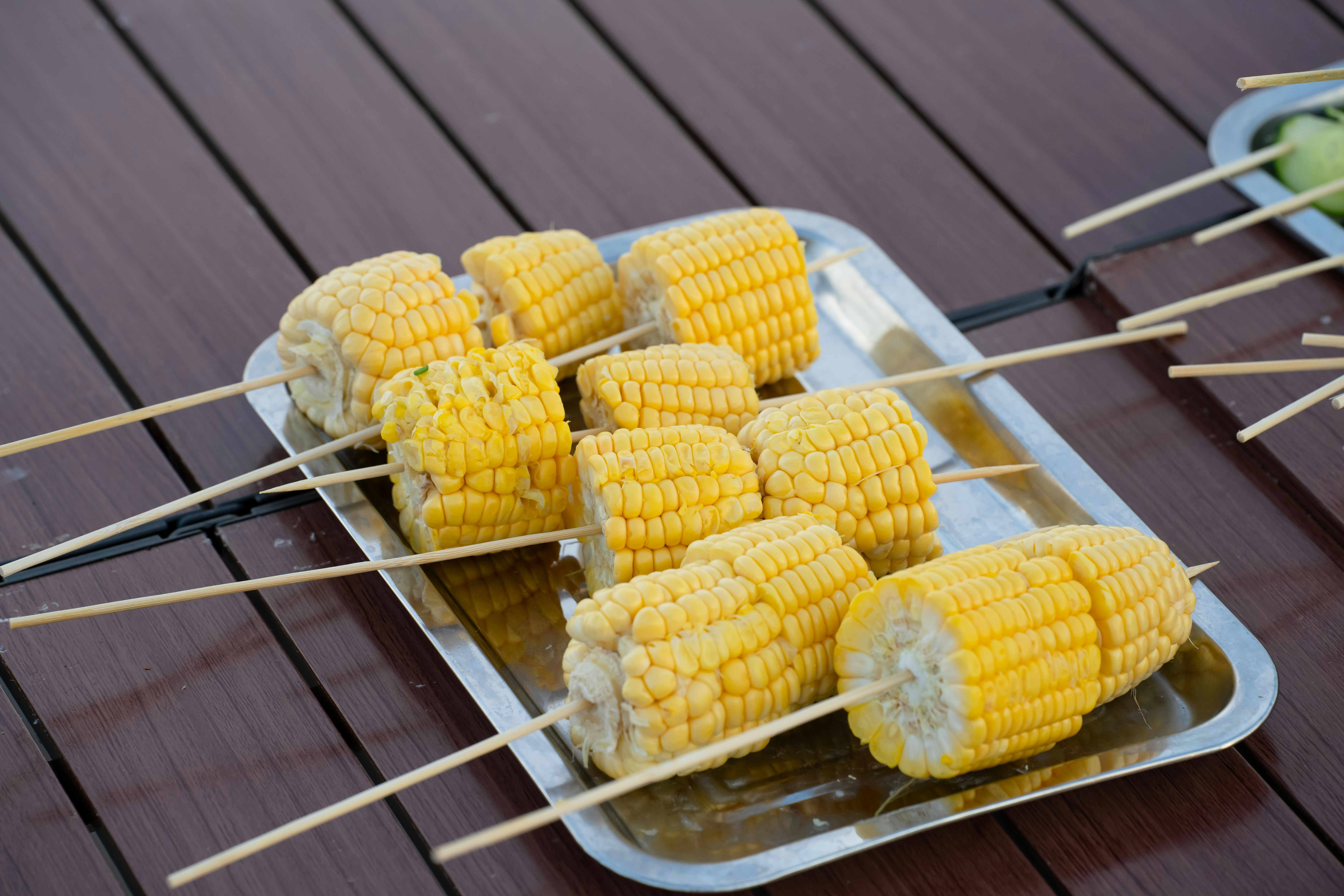 Skewered Sunshine: Corn on a Tray Under Evening Light