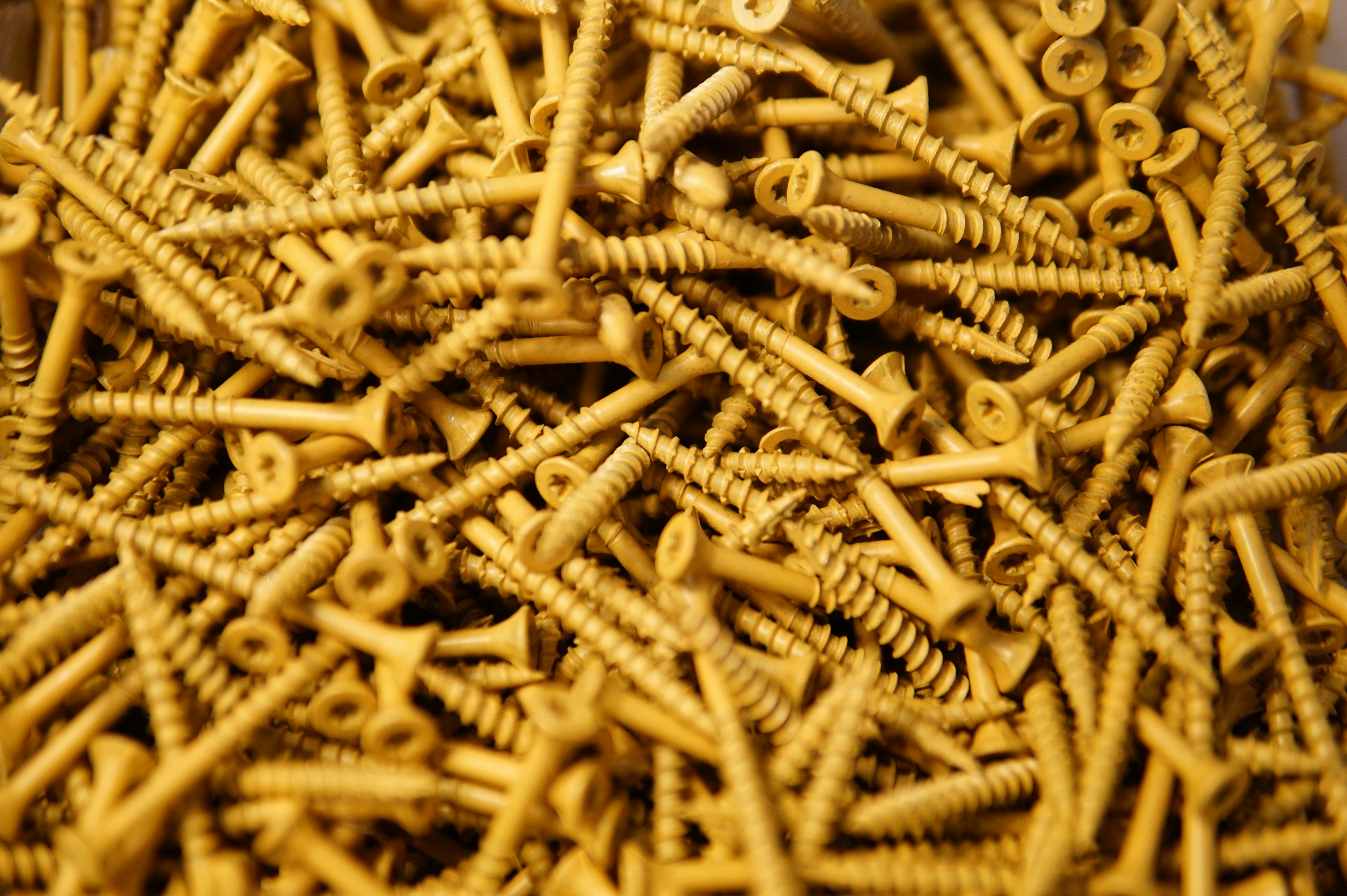 Macro Salt-and-Pepper: A Sea of Tiny Golden Screws (screws close-up in warm-toned frame)
