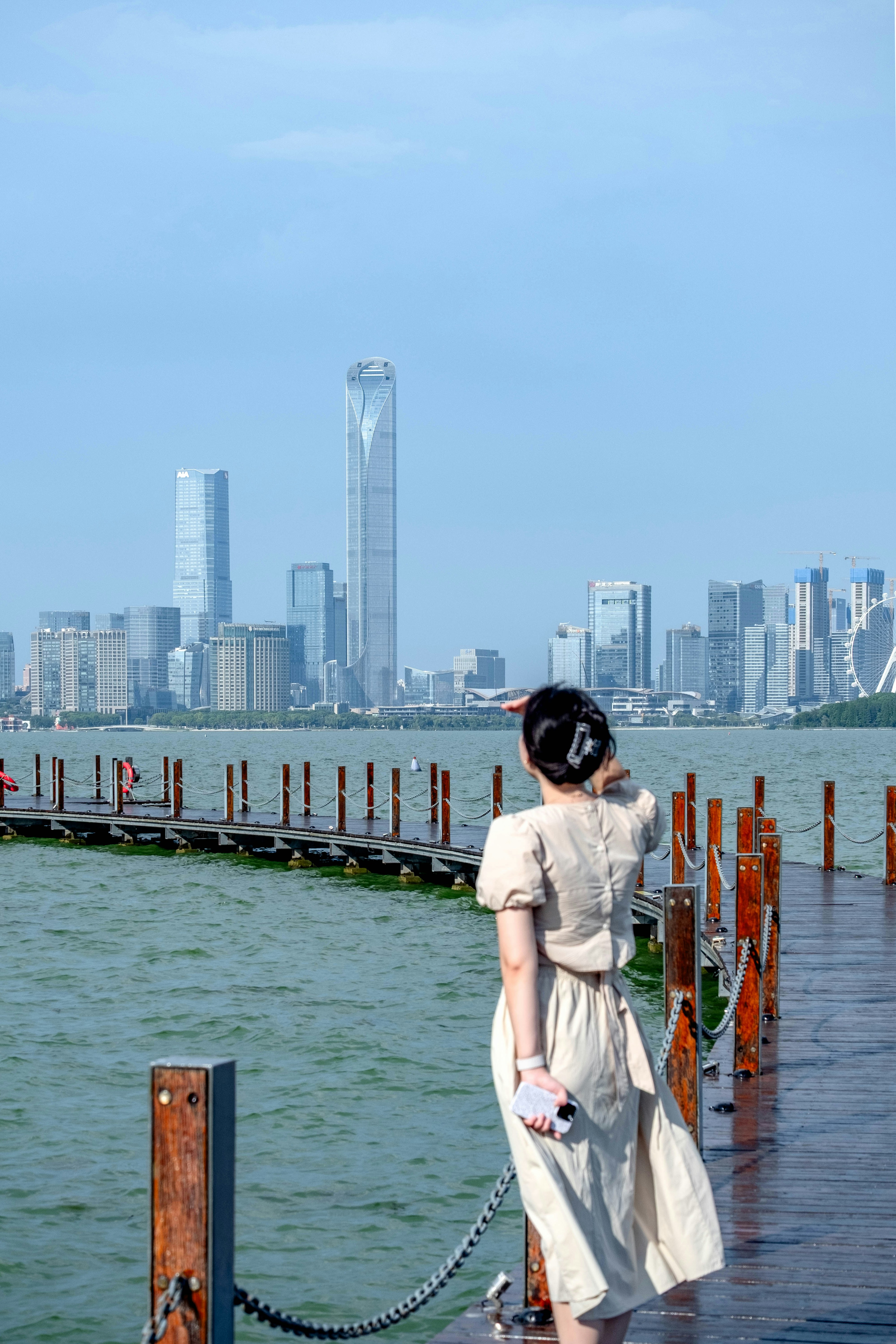 Silhouette on the Pier: A Walk Toward the Skyline