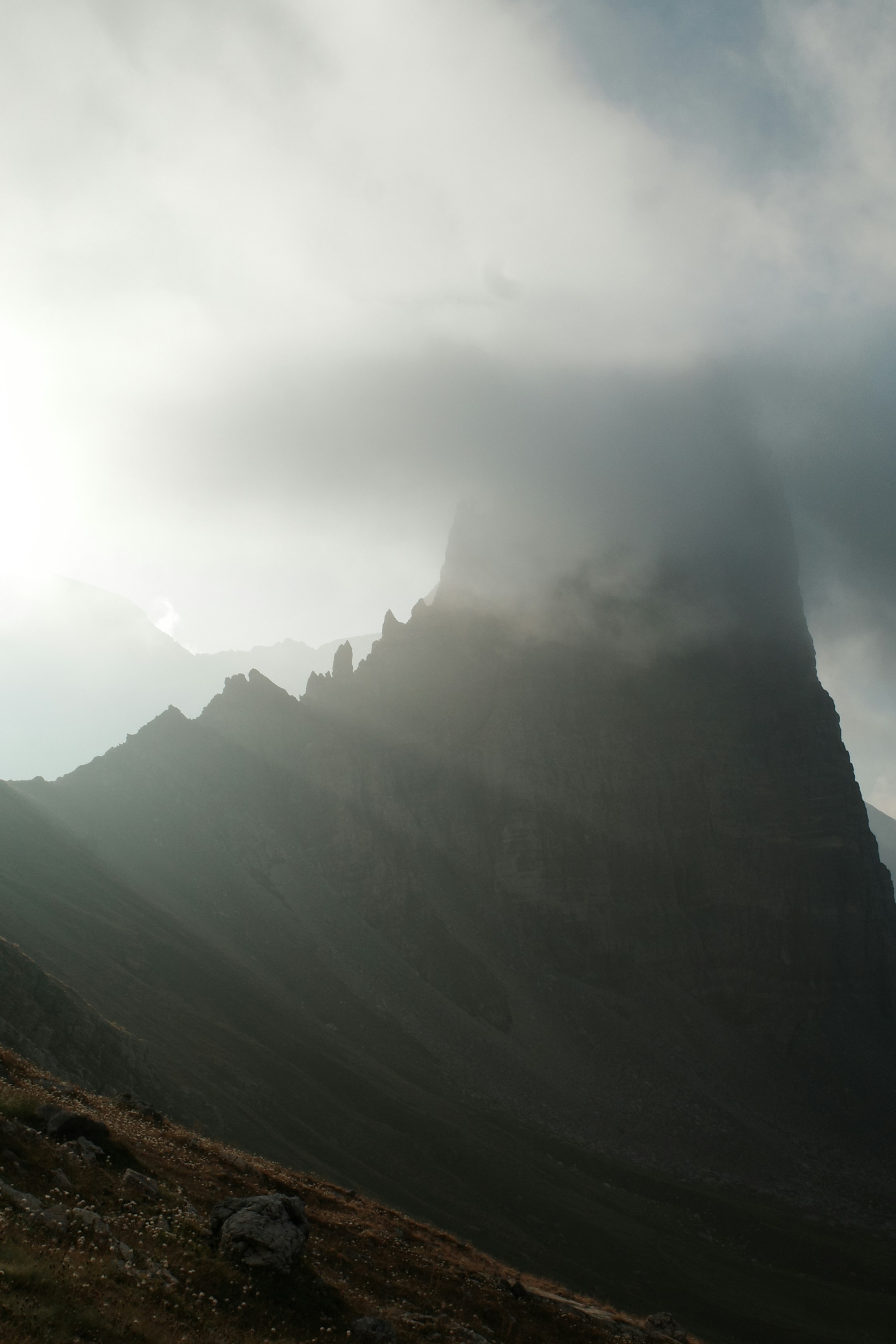 Peak Wath of Light: Cloud-Crowned Summit Emerging from Shadow