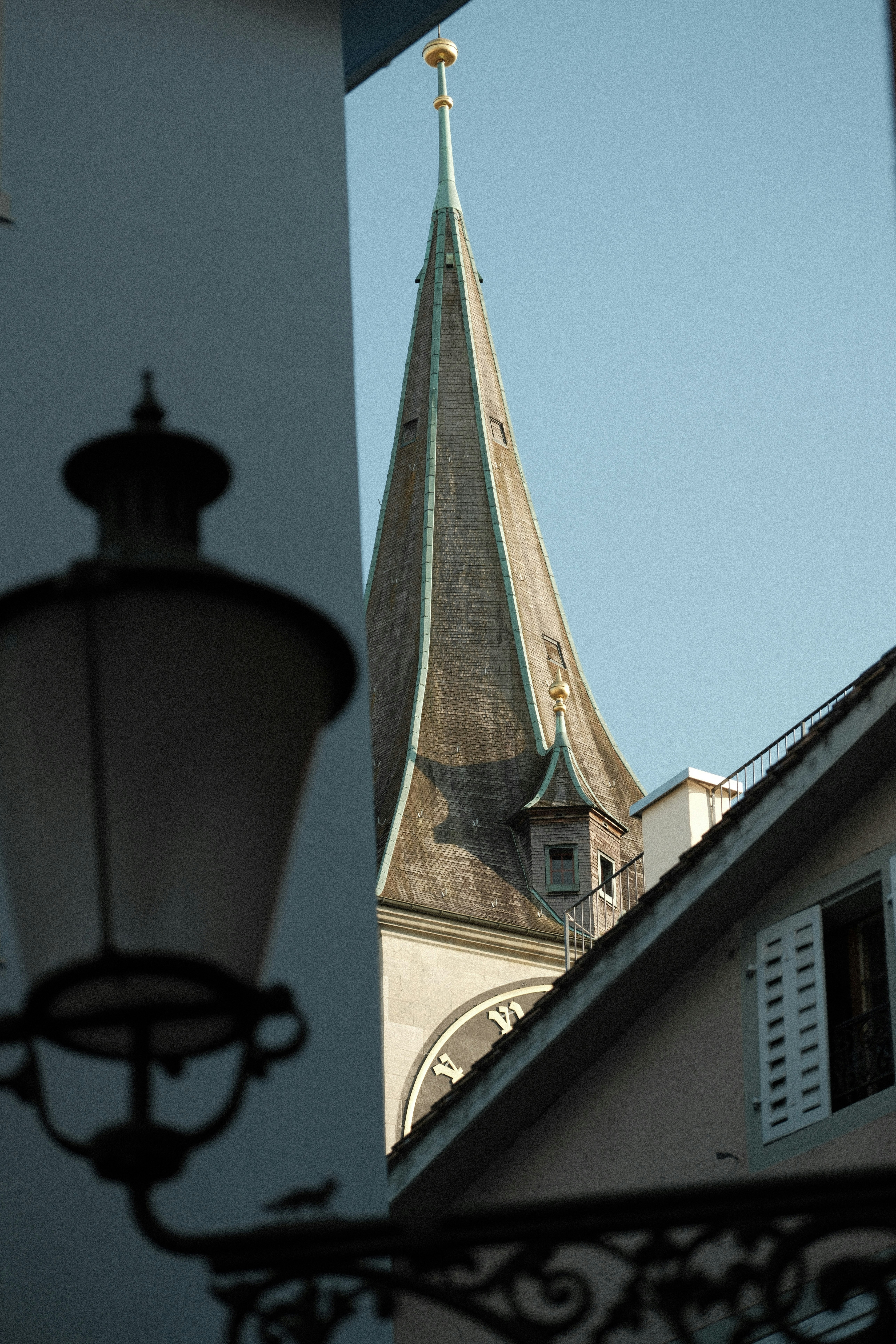 Steeple Between Shadows: A Narrow View of a Bell-Topped Spire