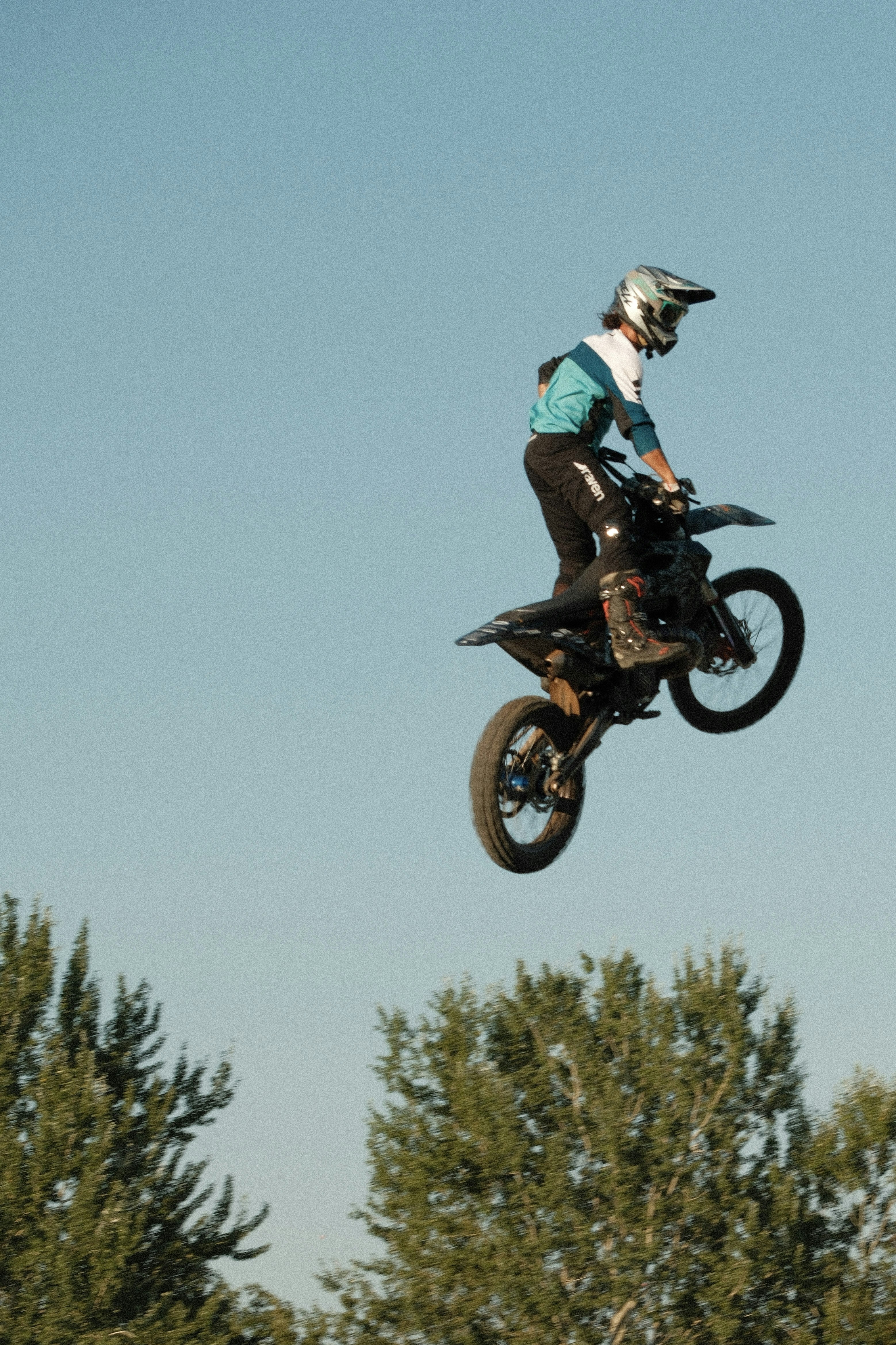 Mid-Air Leap: Rider Soars Against a Clear Blue Canvas