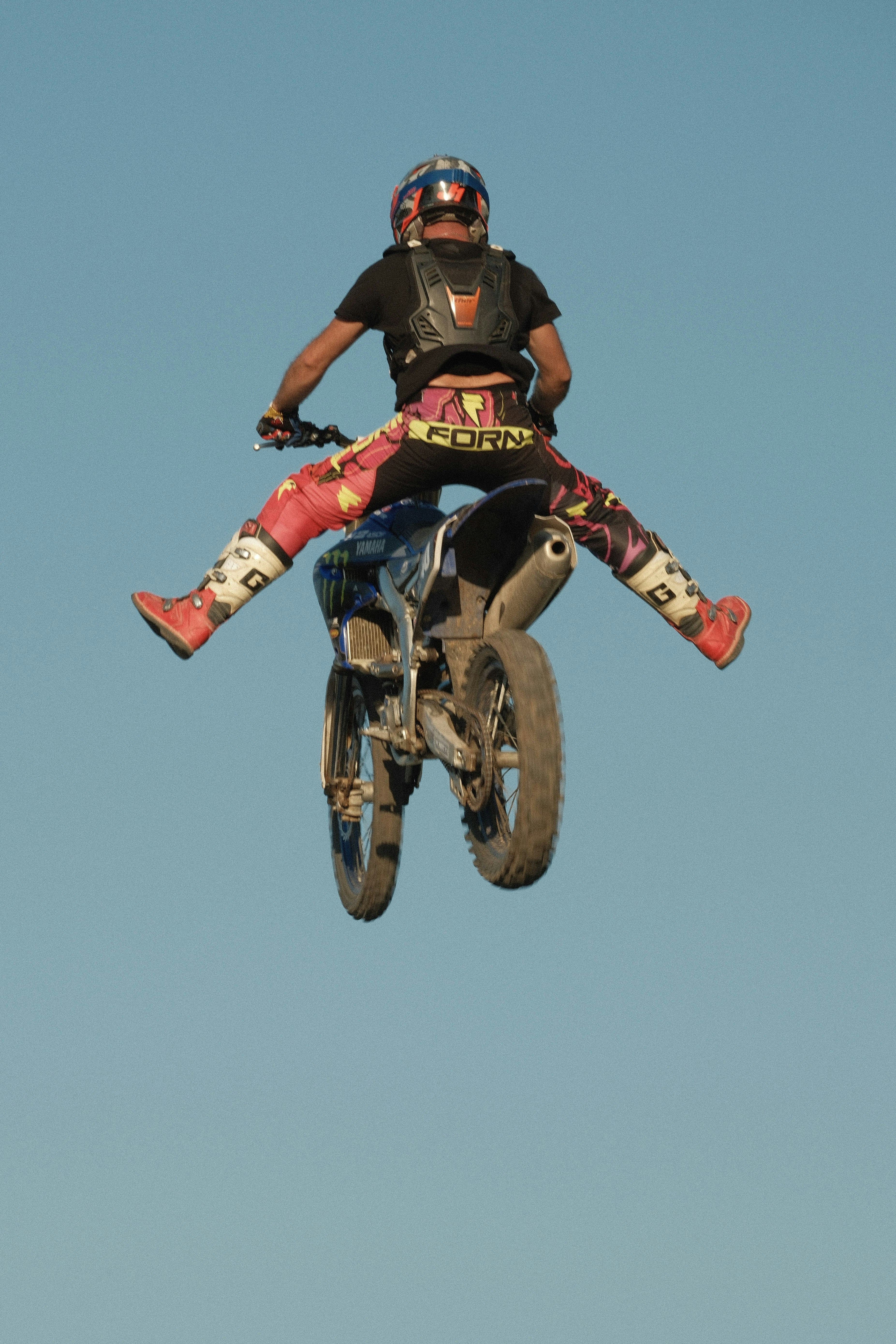 Aerial Freestyle: Rider in mid-flight against a clear sky
