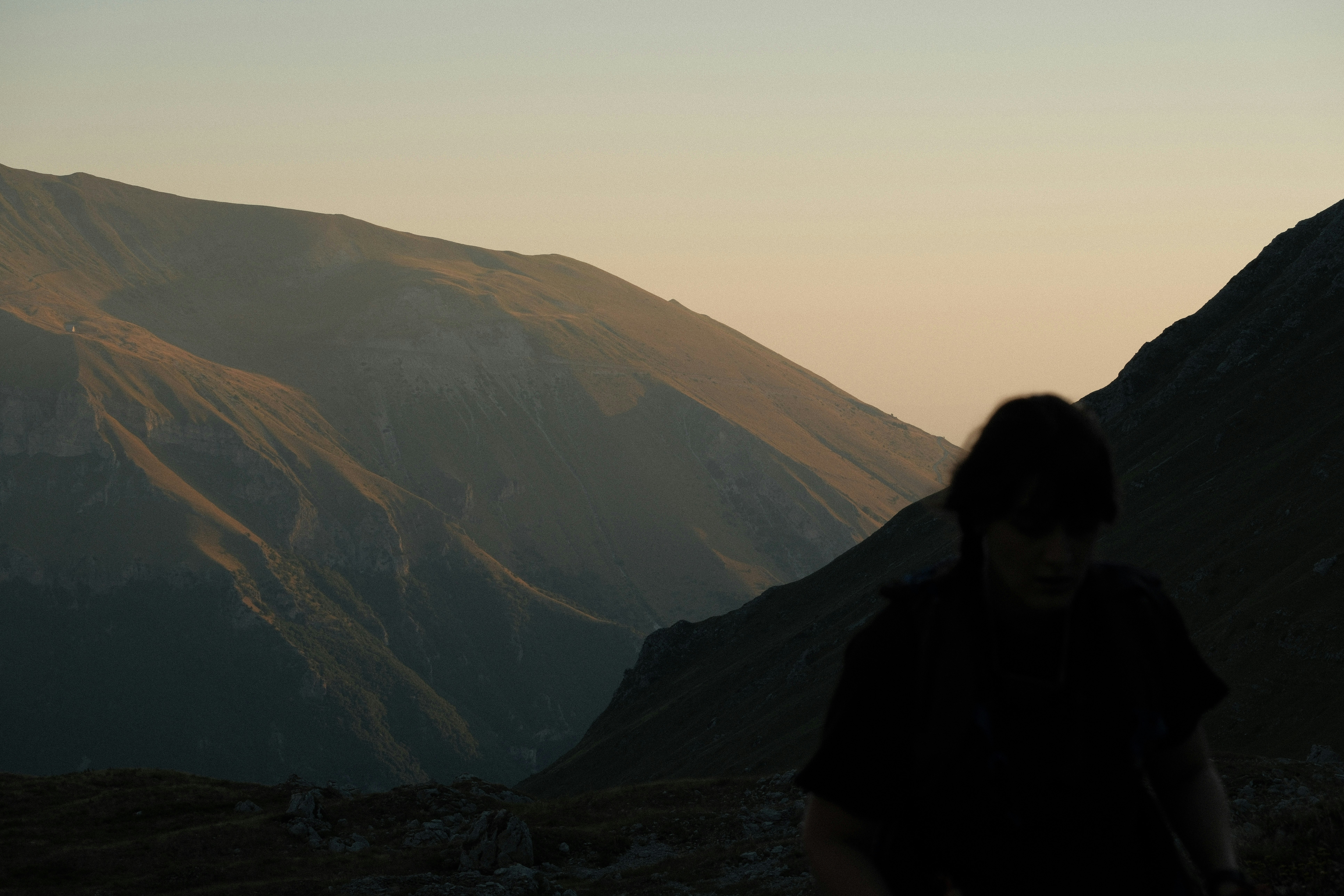 Shadowed Explorer Amid Mountain Trenches at Golden Hour
