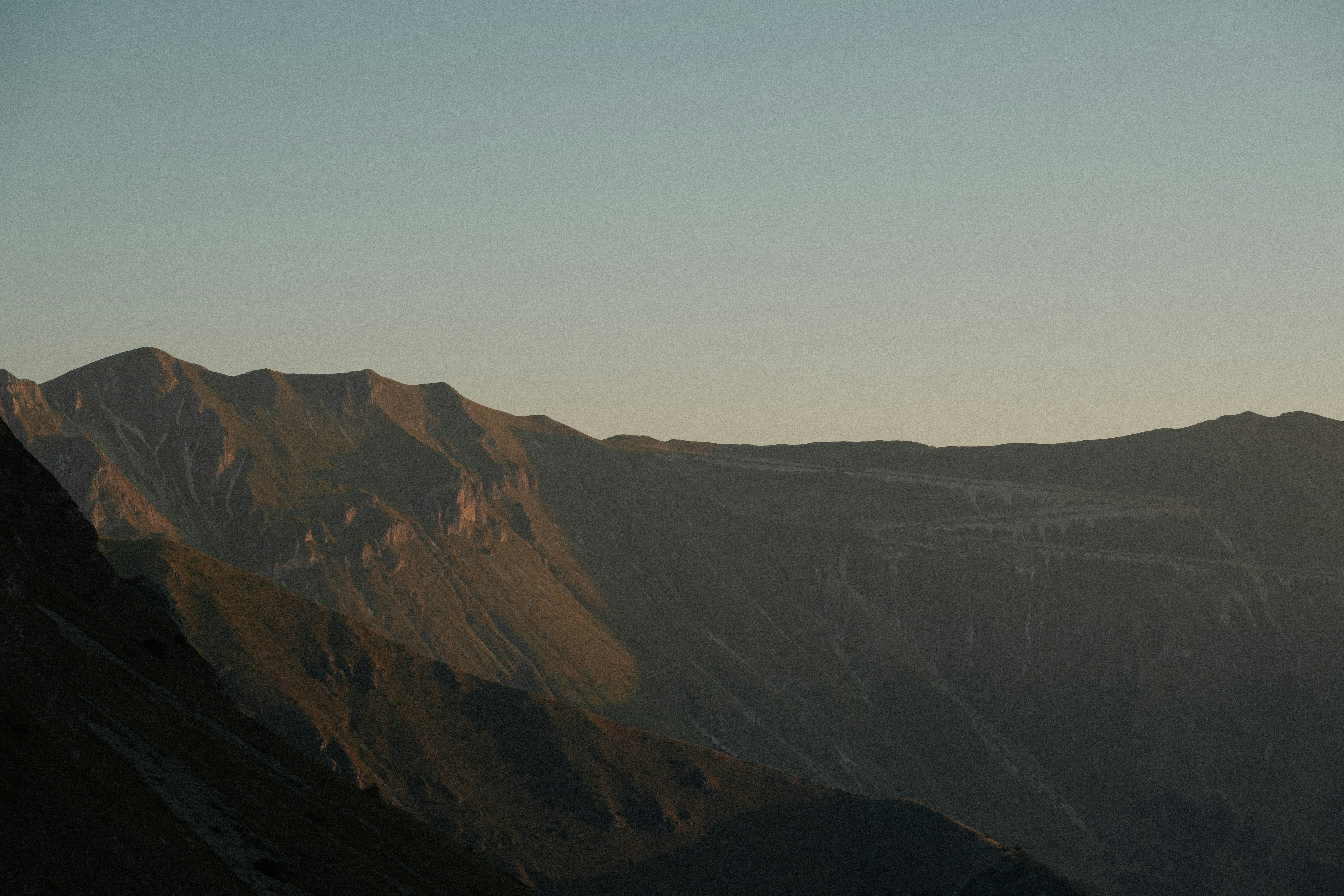 Muted Horizon: A Sunlit Ridge Cast in Evening Light