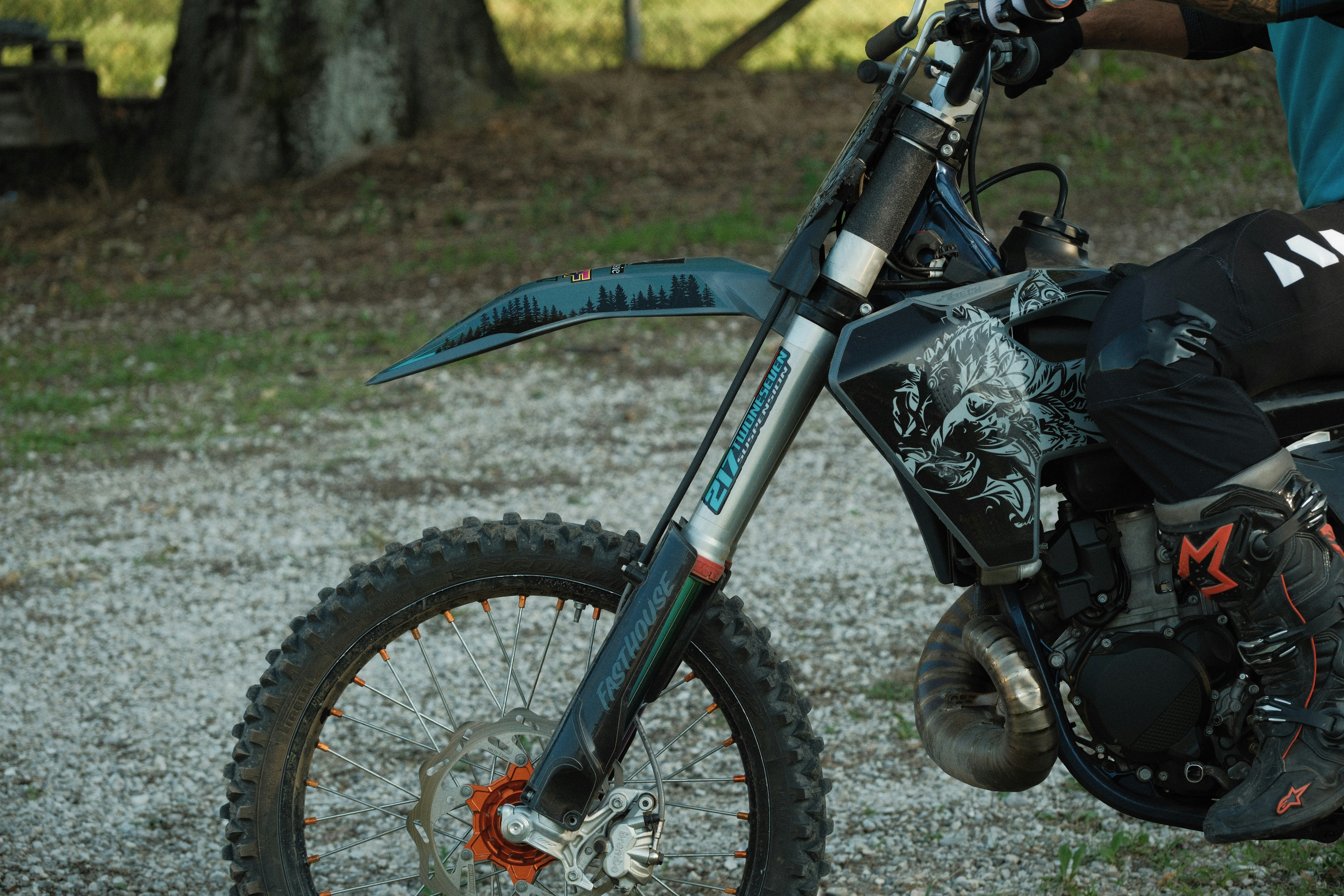 Blue Trail Beast: Front Wheel in Focus amid Forest Gravel