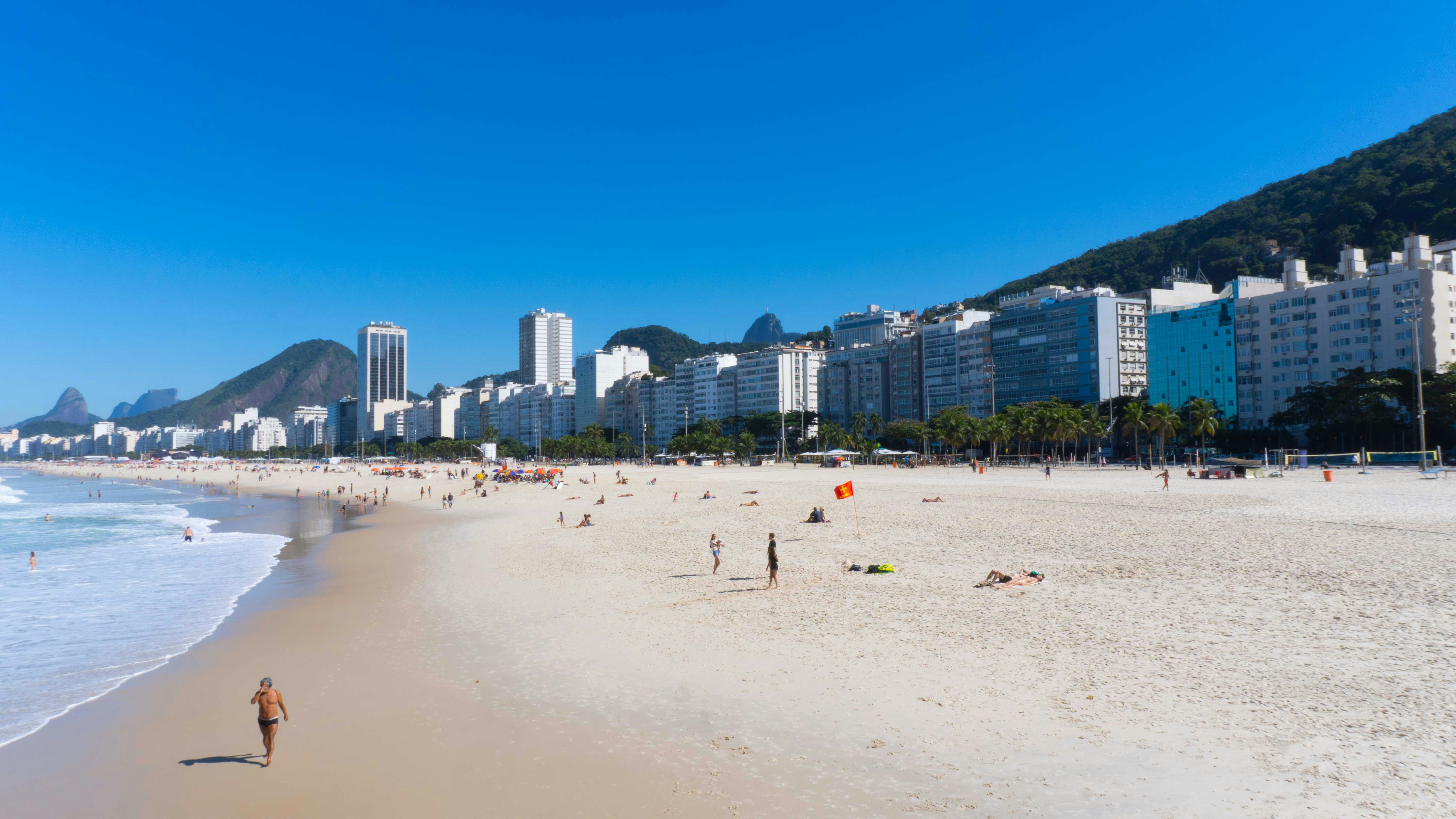 City Slopes Meet Sands: A Rio-Style Beachfront Under a Clear Coastal Sky