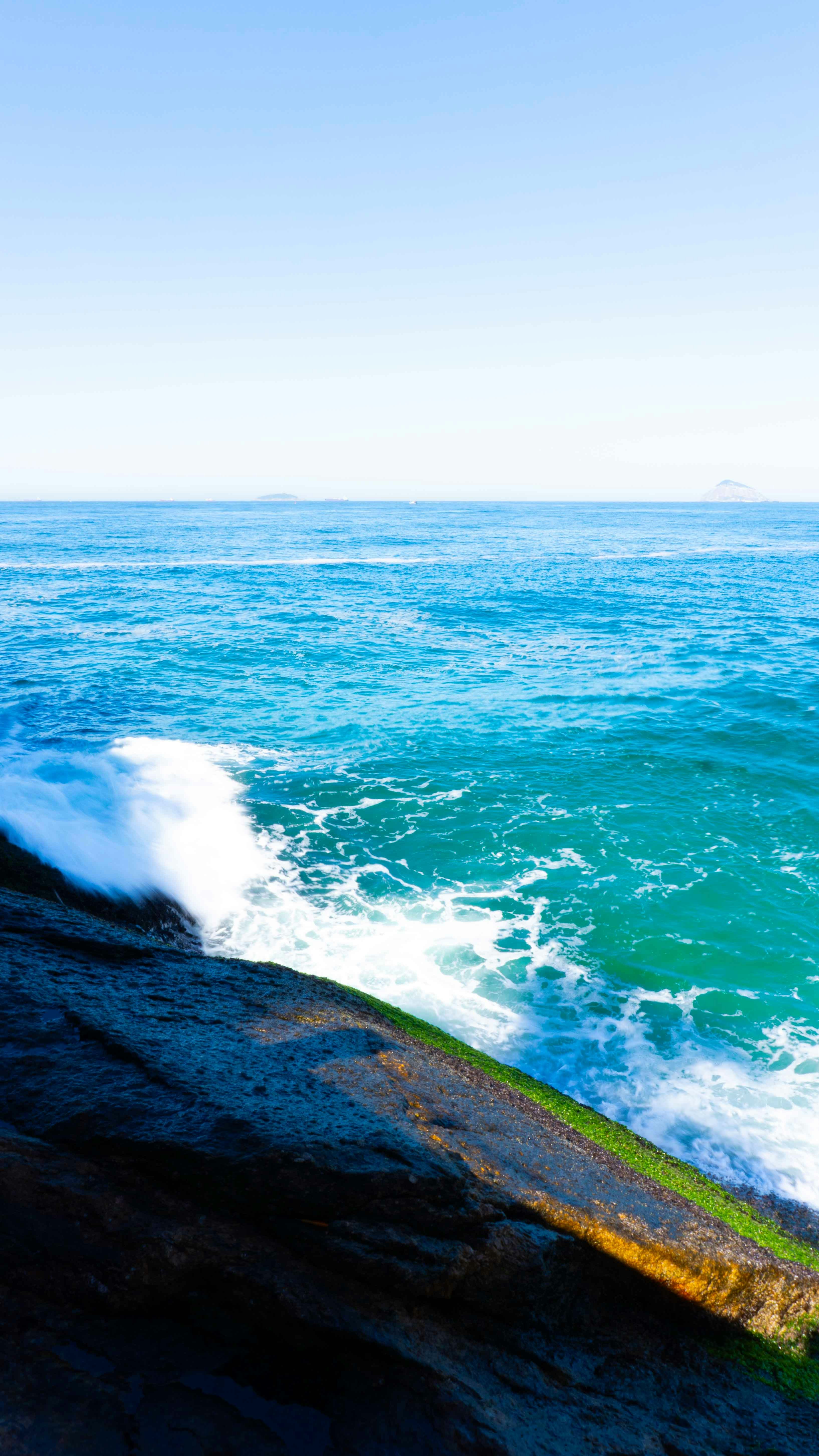 Silver Horizon: Ocean Waves Meet Mossy Rocks