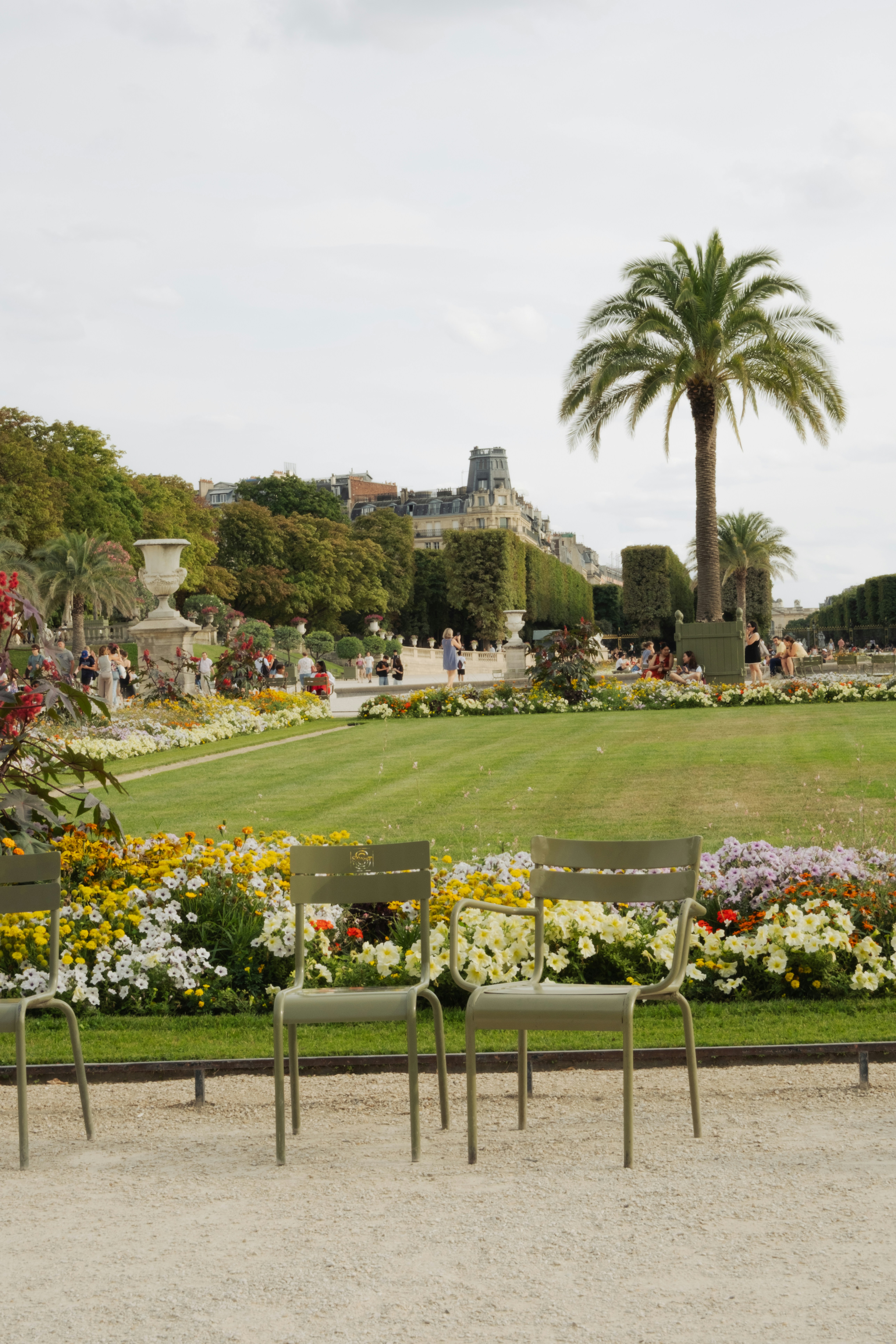 Garden Chairs Amid Colorful Beds with a Grand Estate in the Distance