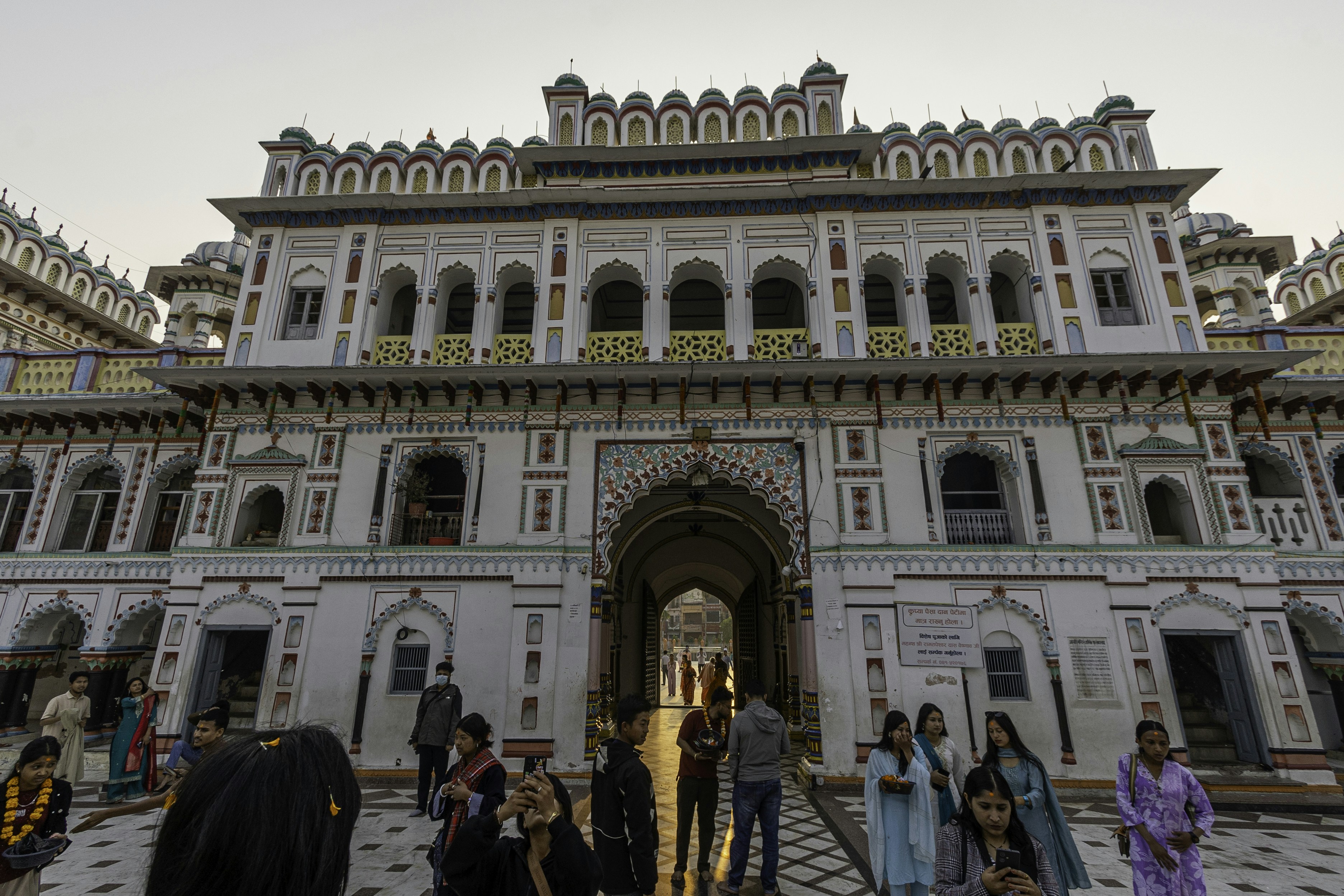 Gateway to Colorful Carvings: A Temple Courtyard Crowd