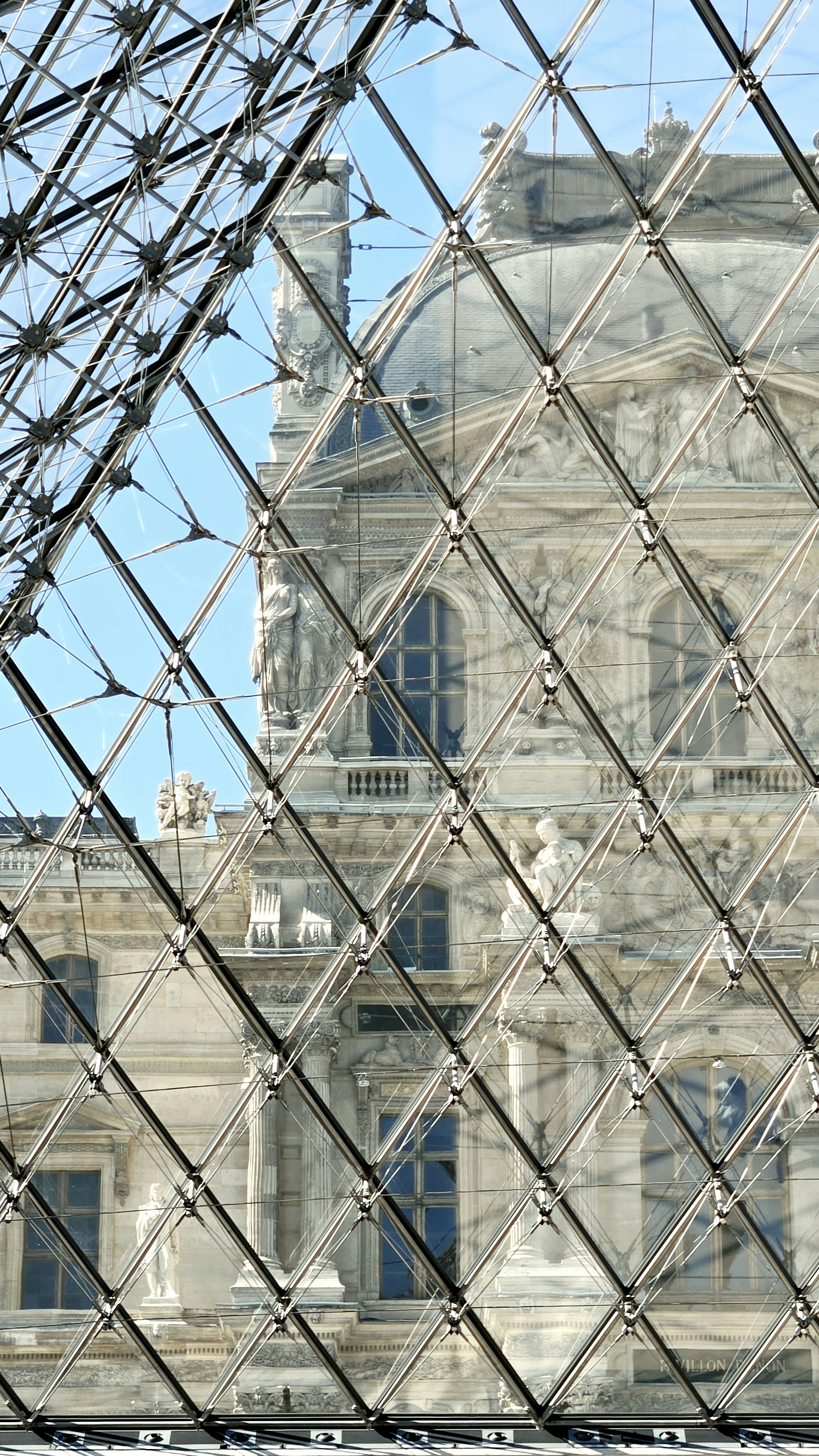 Crisscross of Glass and Stone: The Louvre Pyramid Framing the Historic Facade