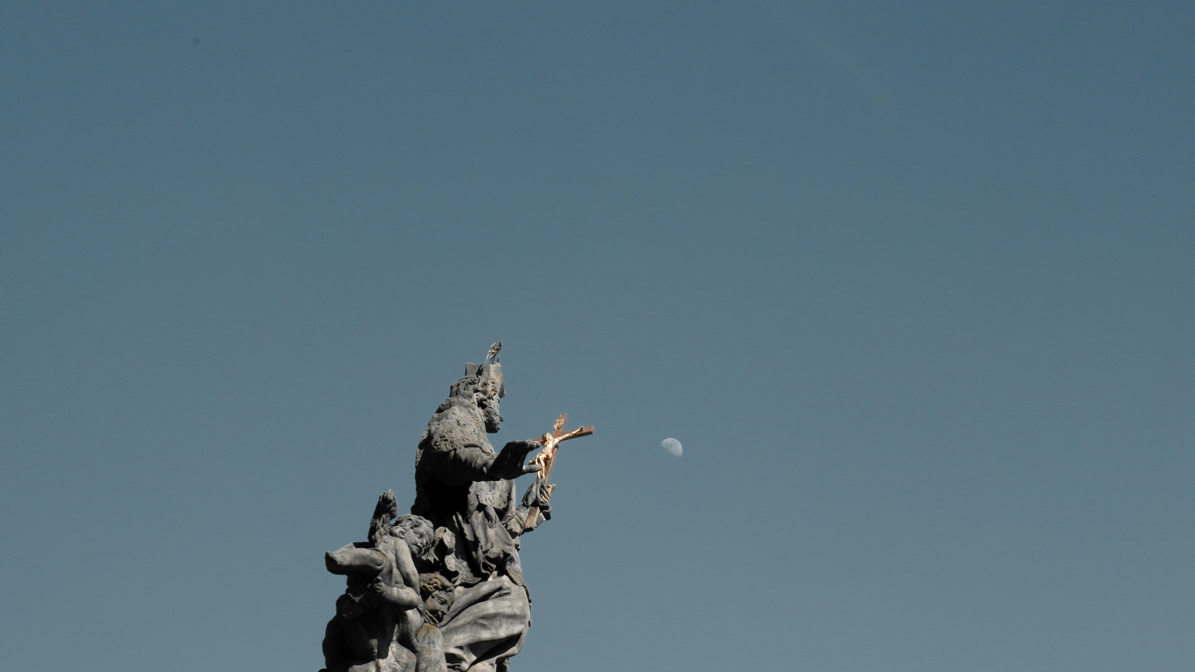 Stone Vanguard: A Weathered Statue Reaching Toward the Sky