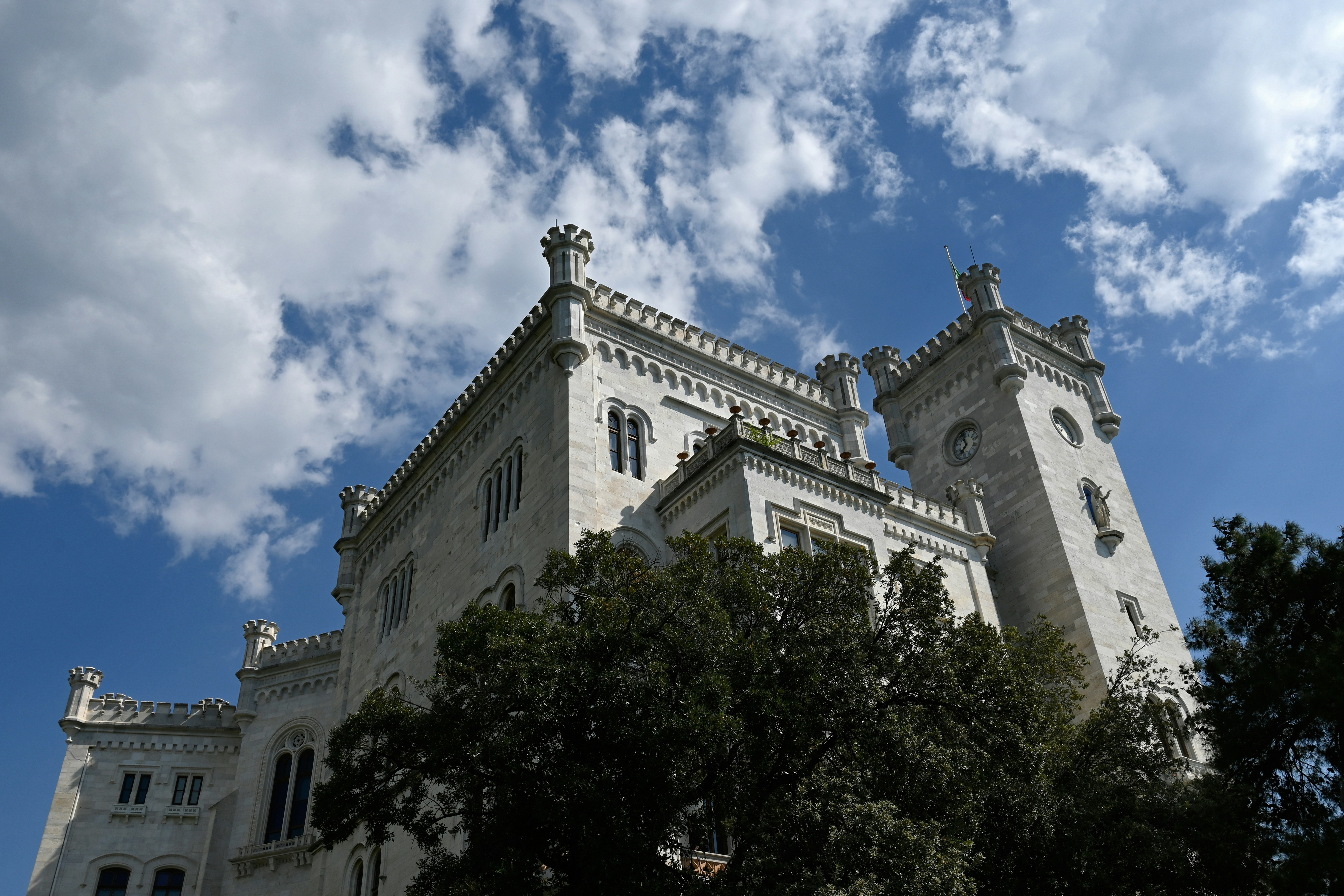 Castle Crowned in Sky: A Sunlit Facade Above Foliage