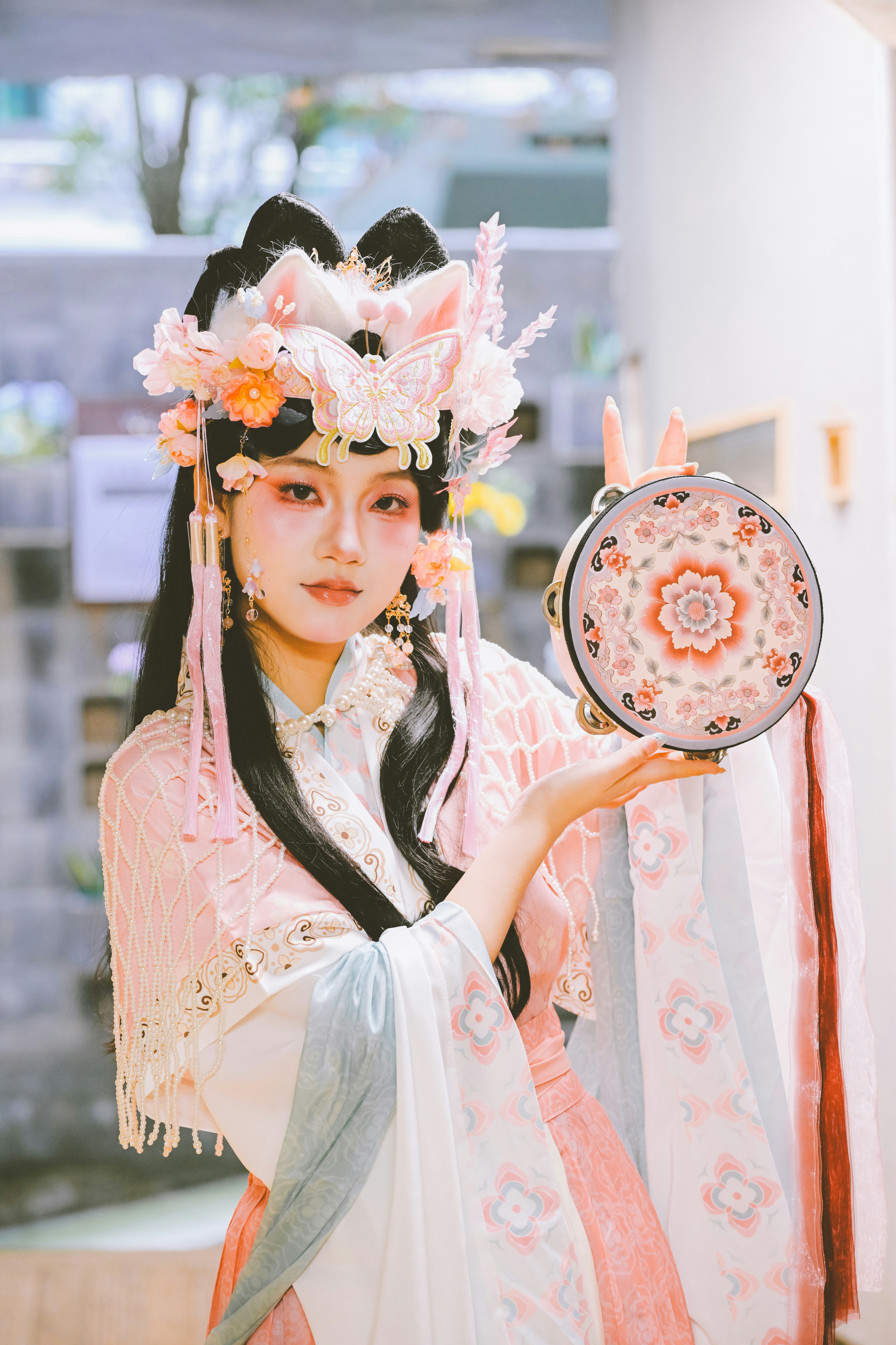 Portrait of a Geisha-inspired performer holding a decorative round mirror