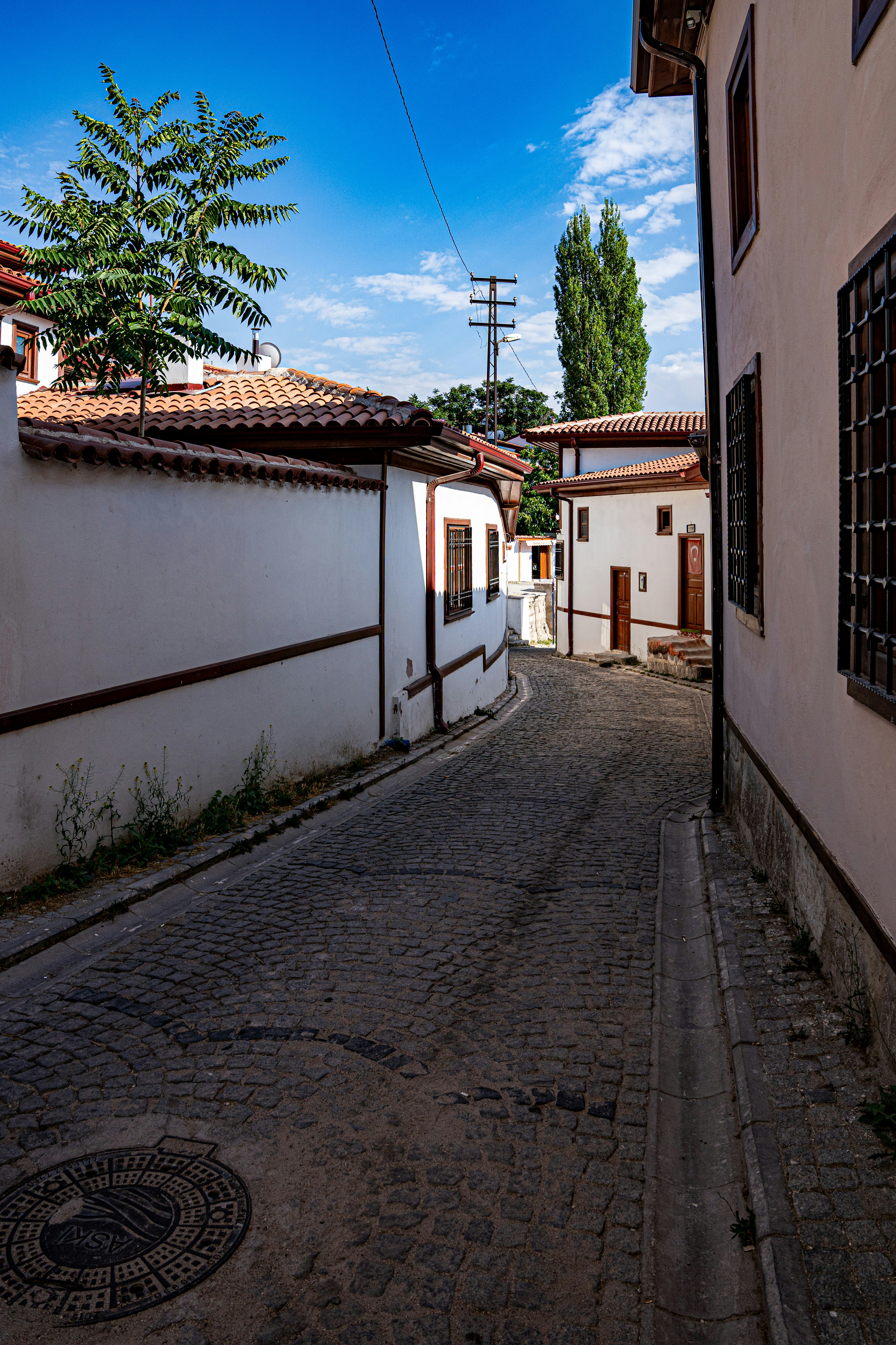 A Quiet Cobbled Corridor Between White-Walled Homes