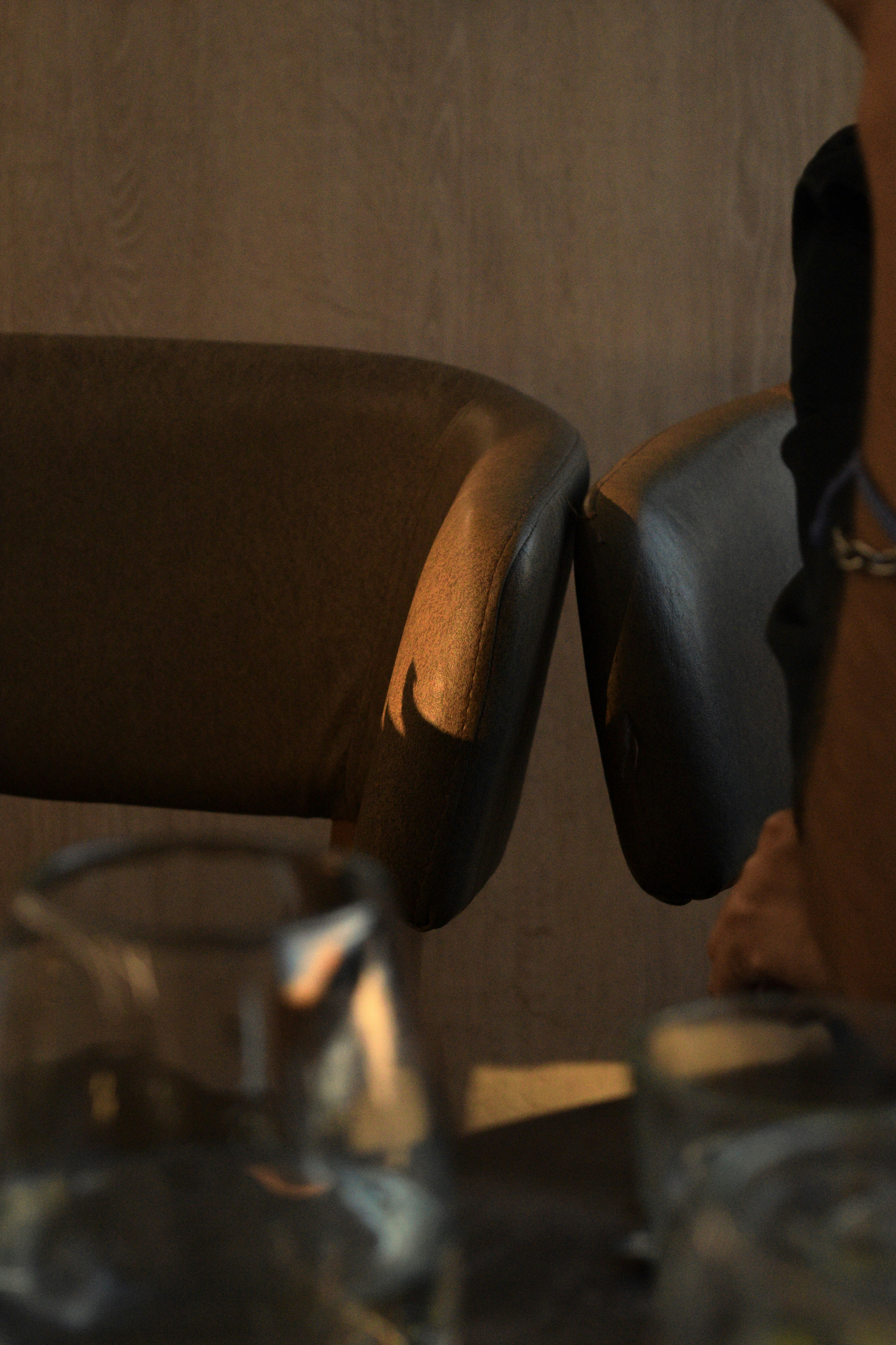 Dim Corner Conversation: Abandoned Seating and Glasses in Low Light