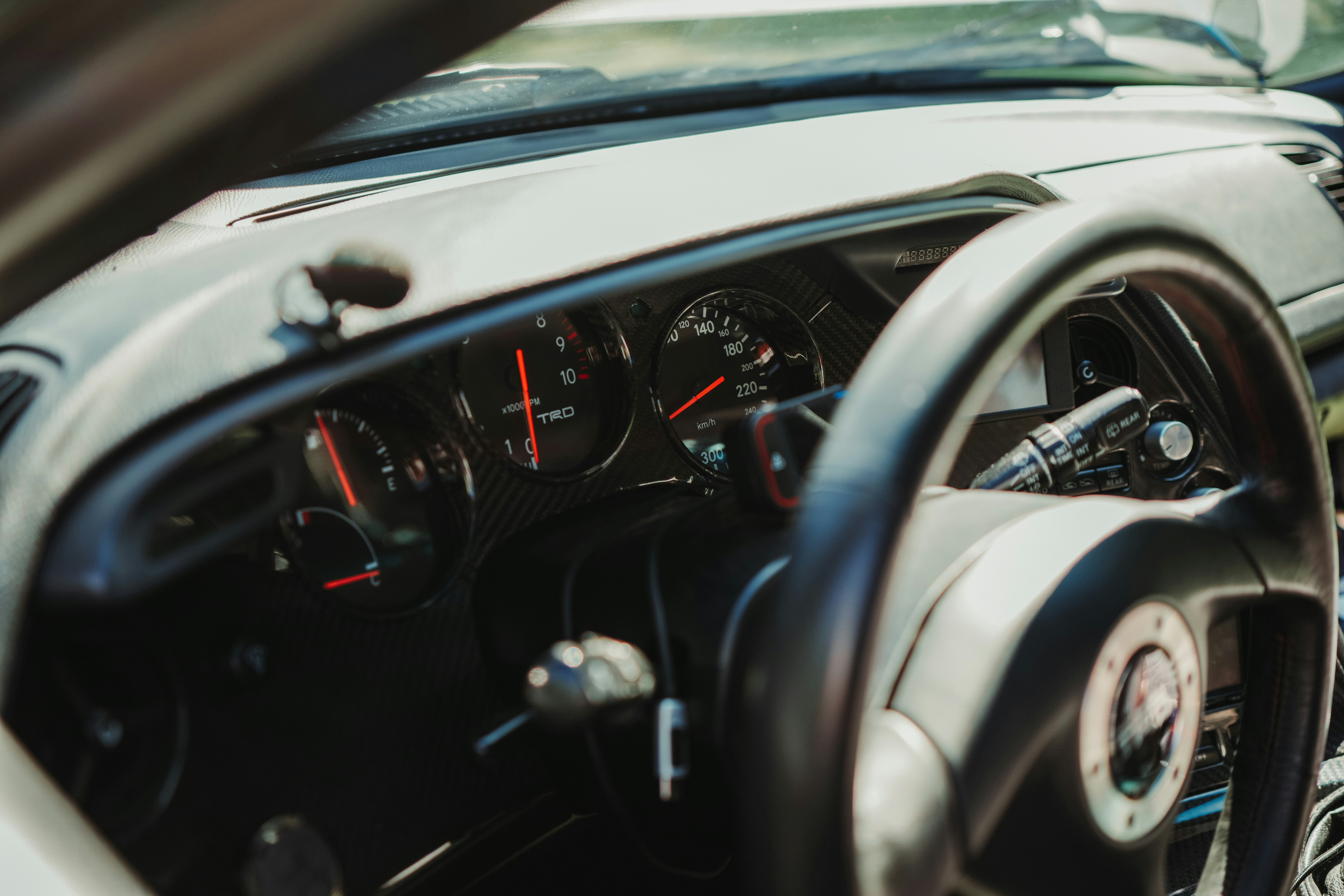 Close-up of a classic car cockpit: gauge cluster and steering wheel in focus