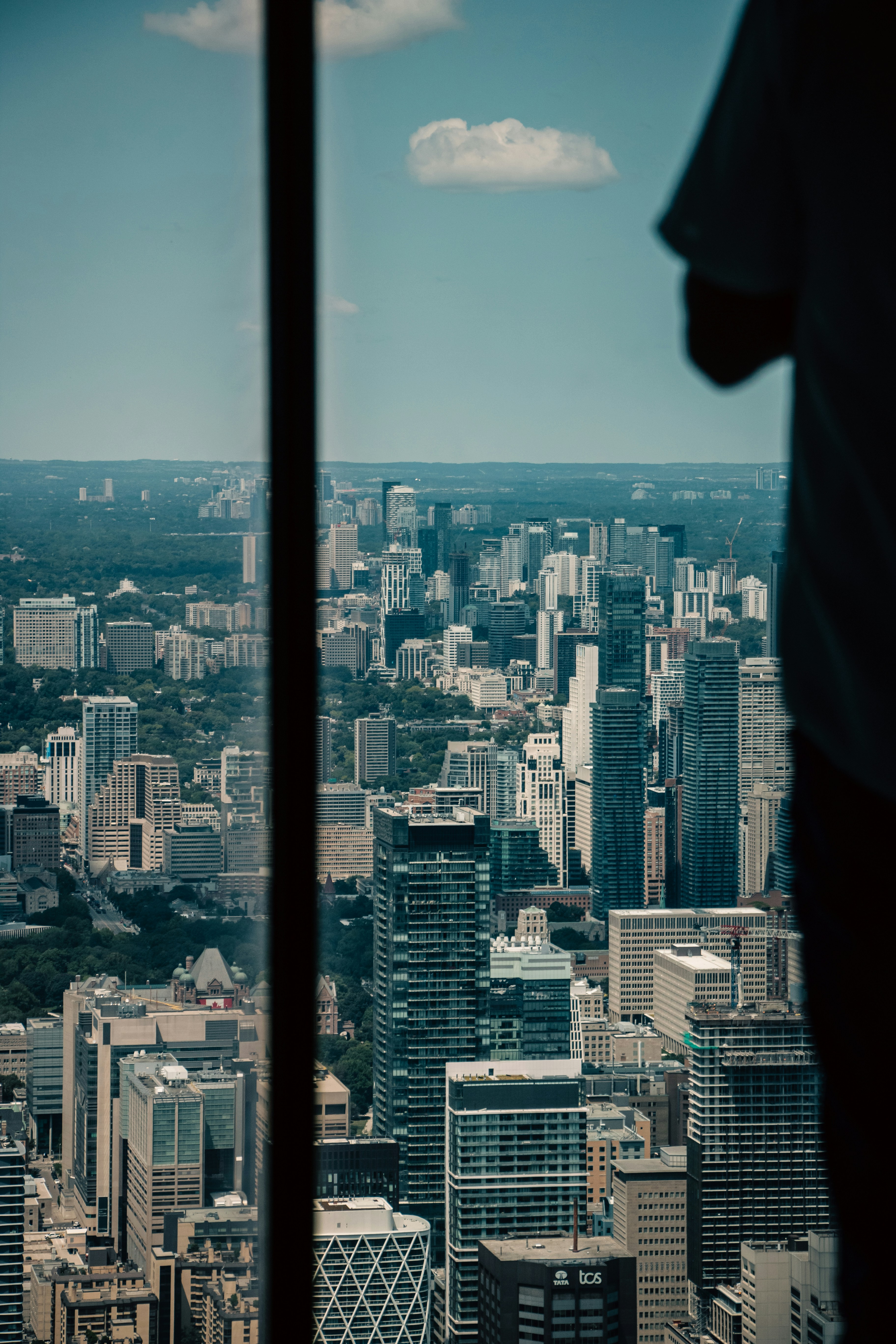 Window to the Skyline: A Shadowed Figure Overlooks a Sea of Towers