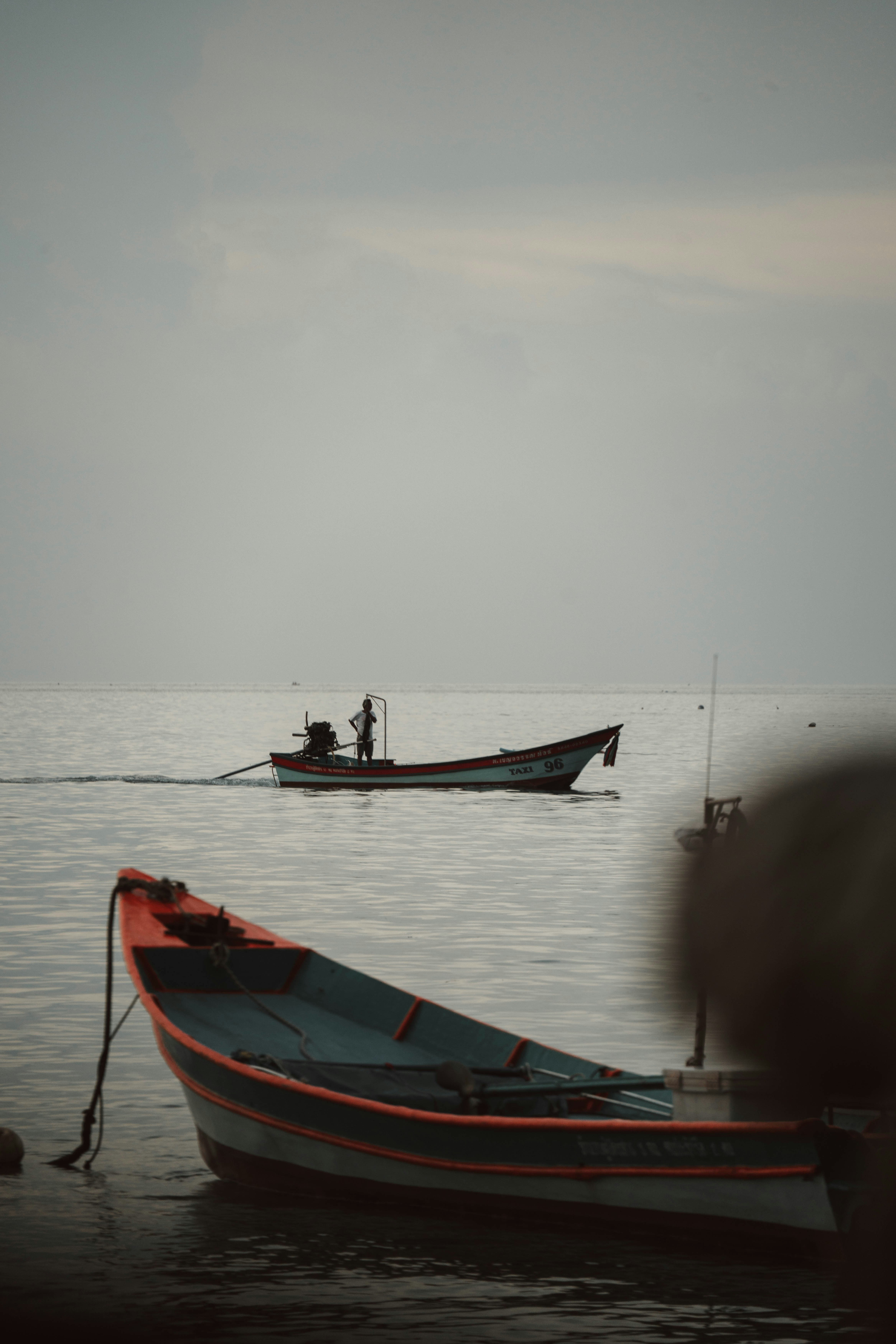 Toward the Horizon: A Quiet Harbor Moment with Red-Trimmed Boats