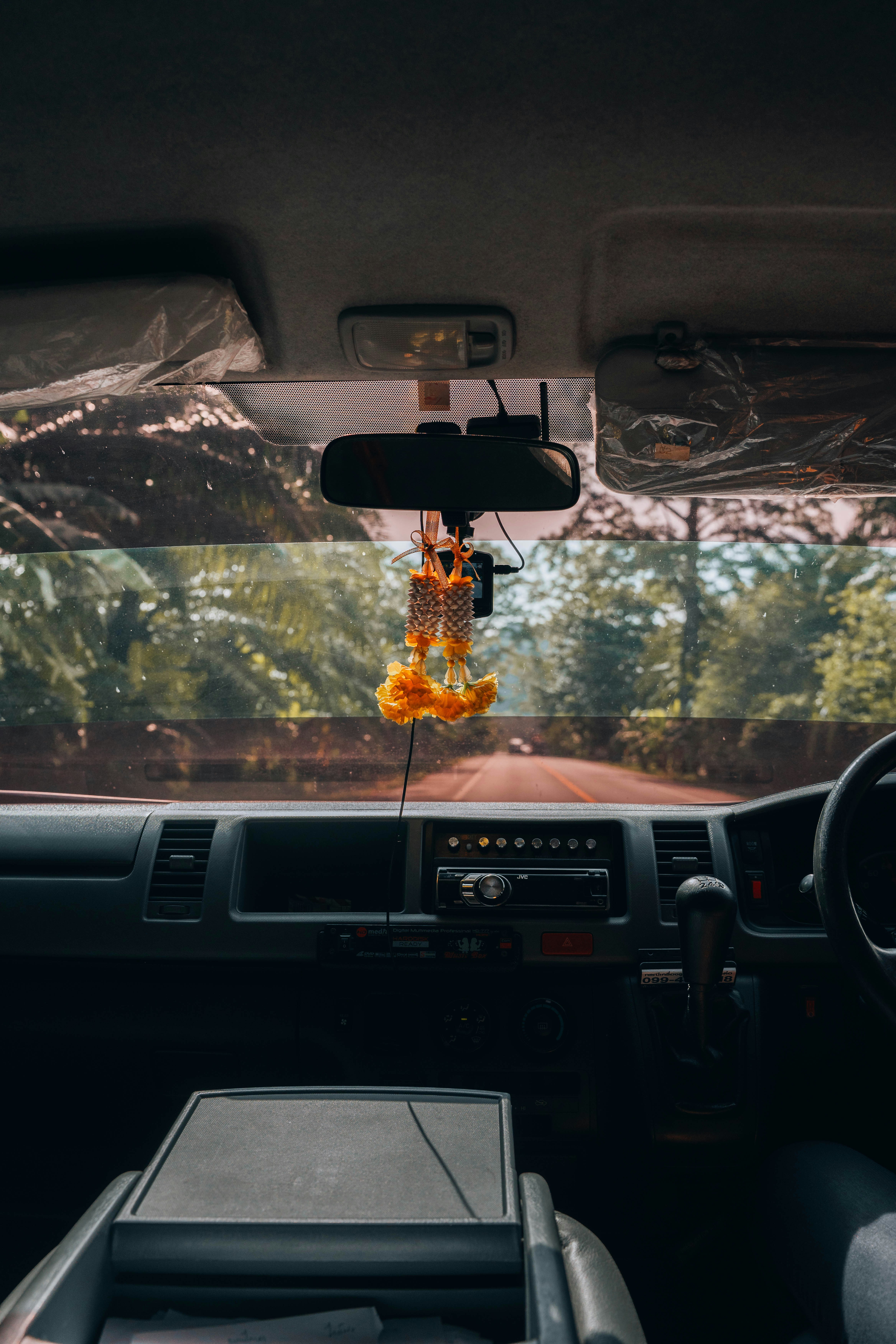 Orange tassels in a moving car: a warm, grounded cockpit view