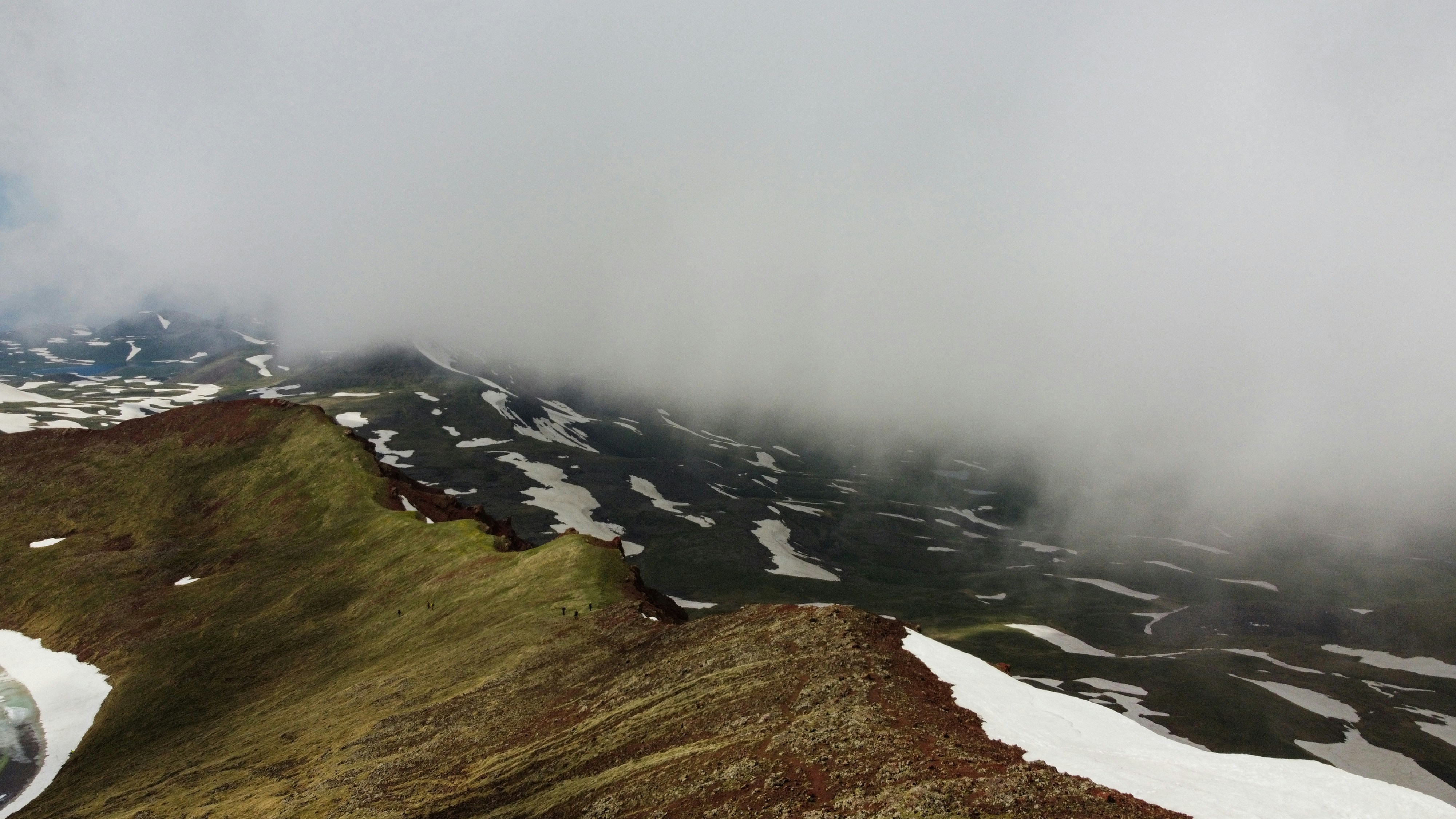 Mist-Clad Ridge Over Snow and Heather