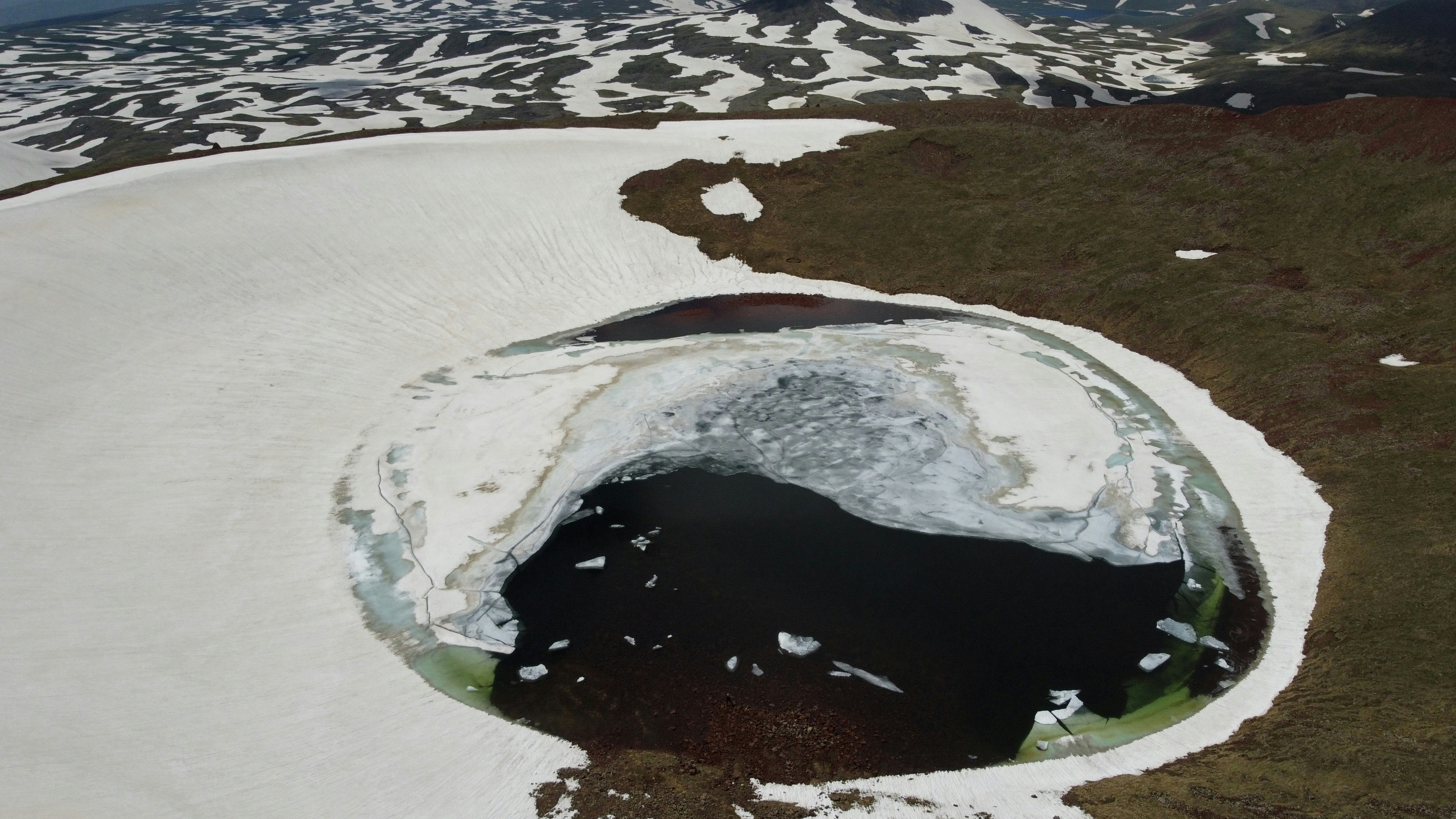 Snow Ring Over a Dark Crater: A Frozen Earth-eye