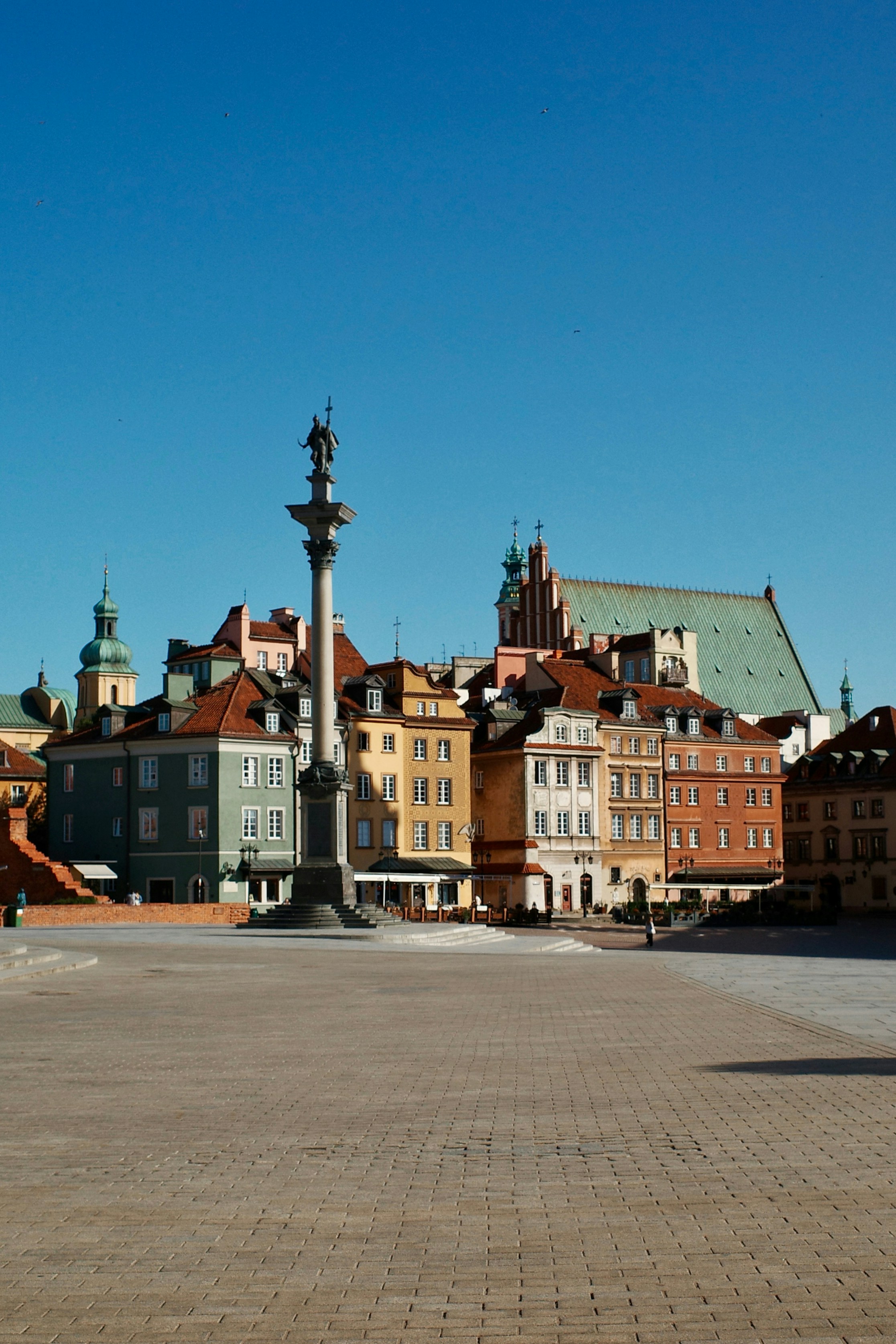 Colorful Row of Historic Townhouses and a Monument in a Sunlit Square