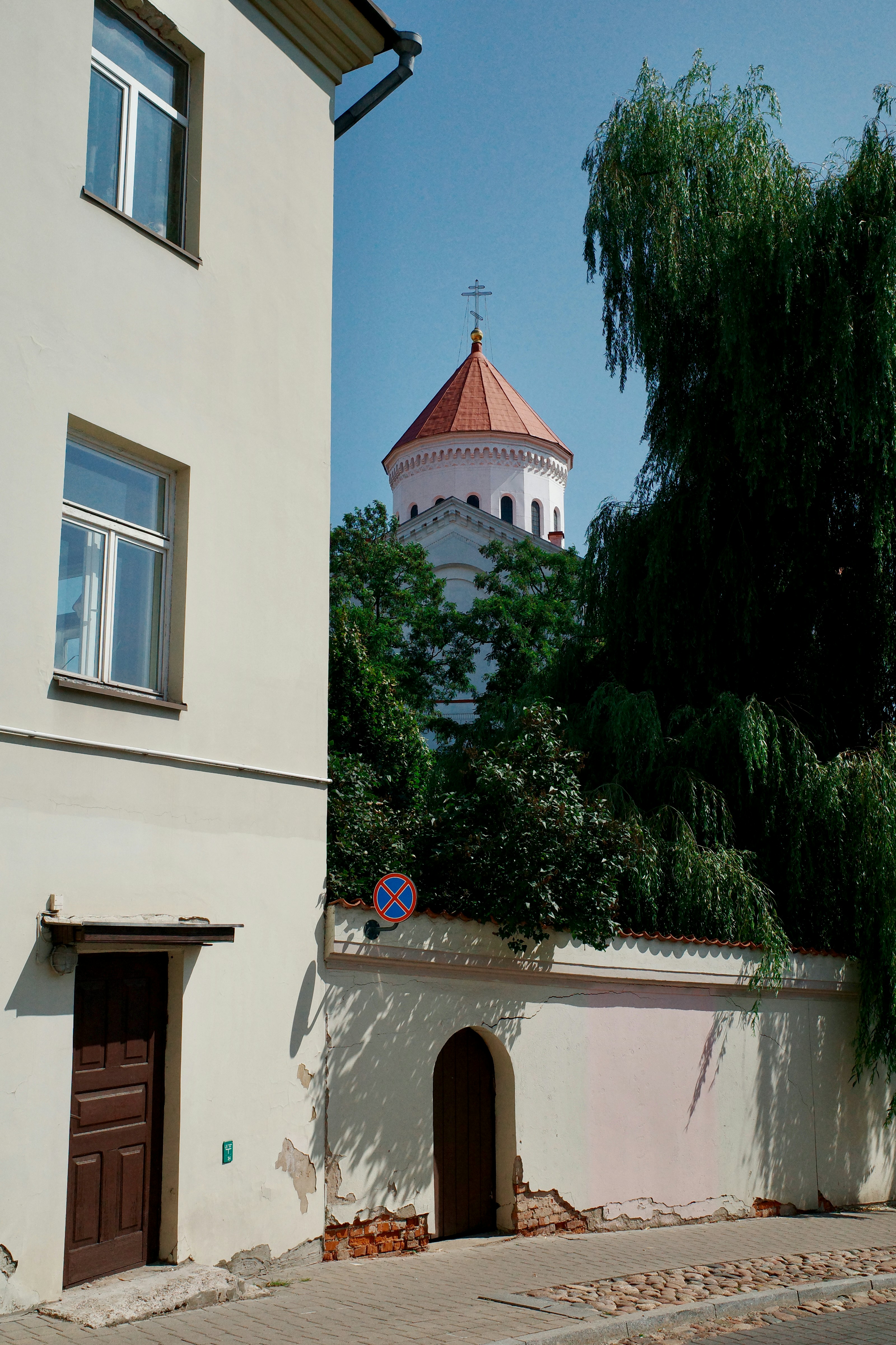 Towered Red Roof Peek: A Quiet Street Framed by Pale Walls