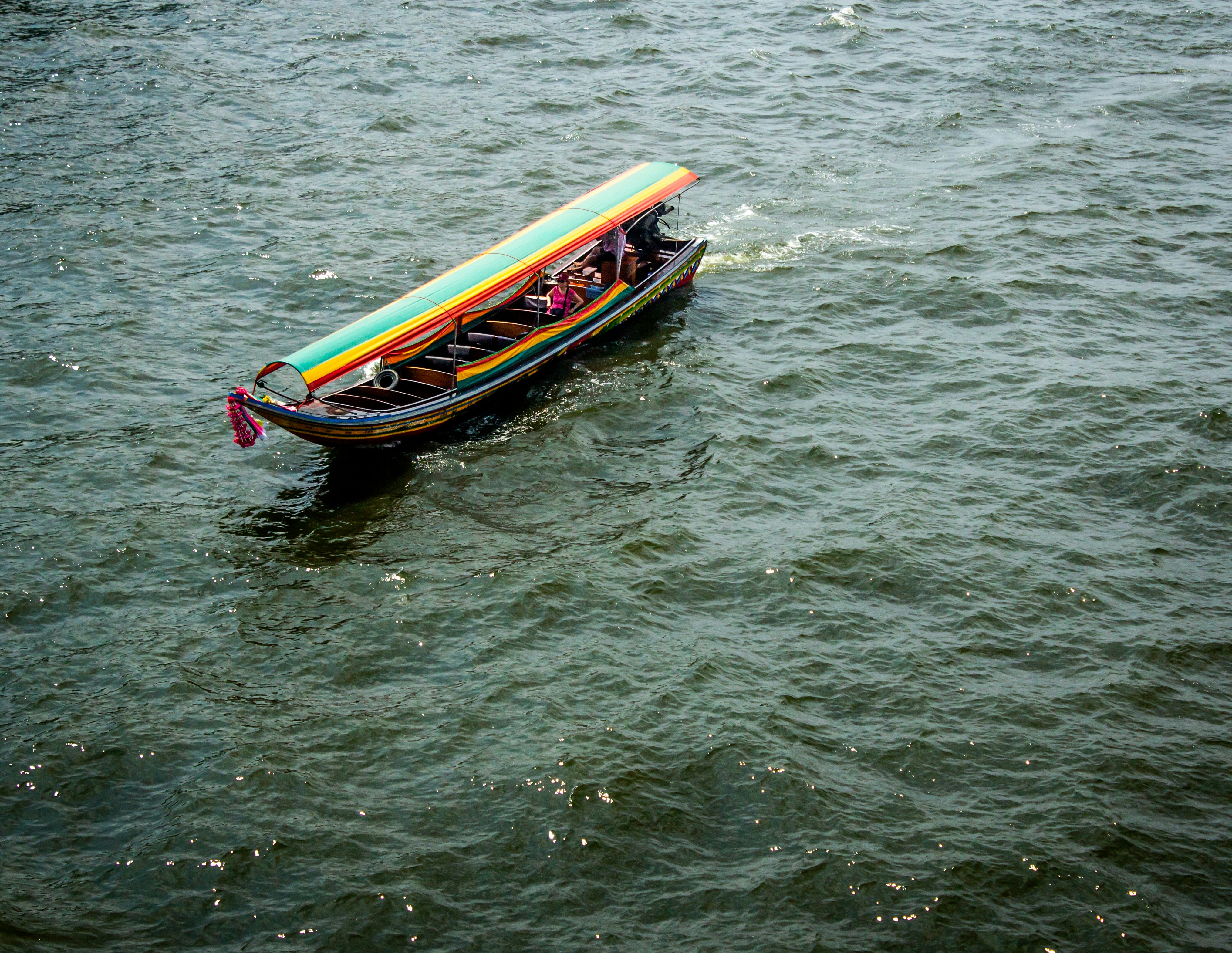 Rainbow Boat Drifting Through Sunlit Currents