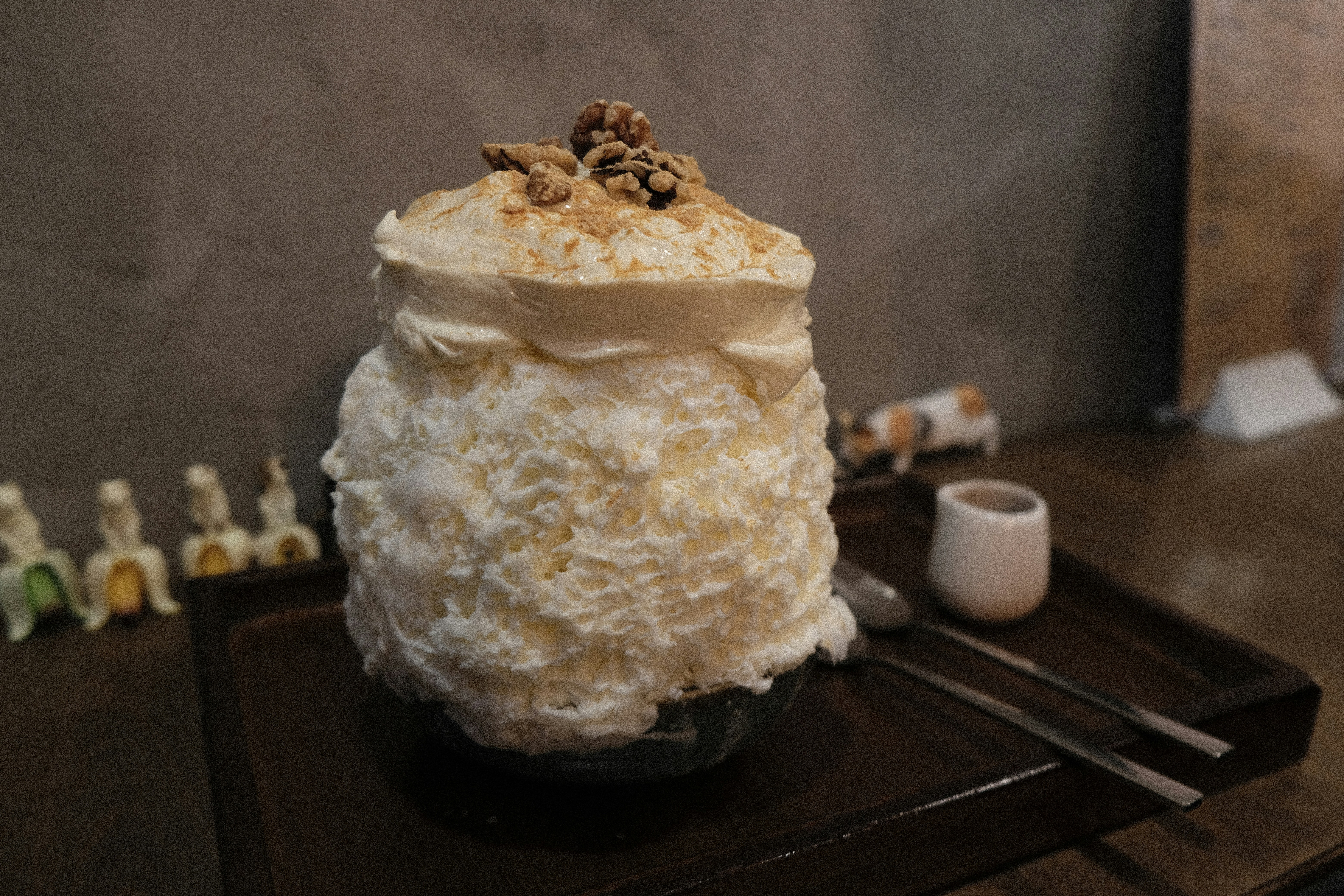 Fluffy snow-kissed parfait perched on a dark wooden tray