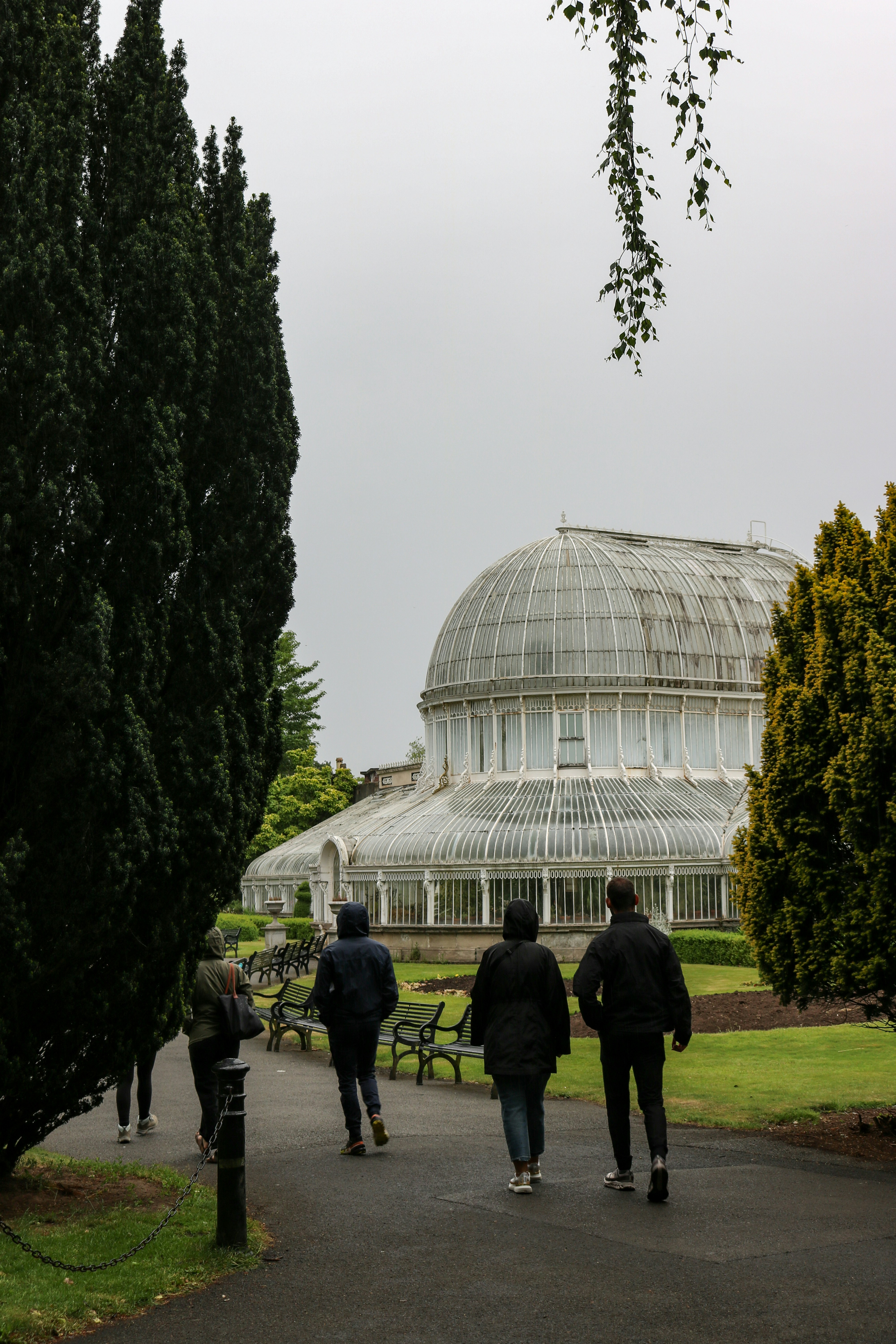 Glasshouse Gate: Visitors Stroll Toward a Dome Conservatory
