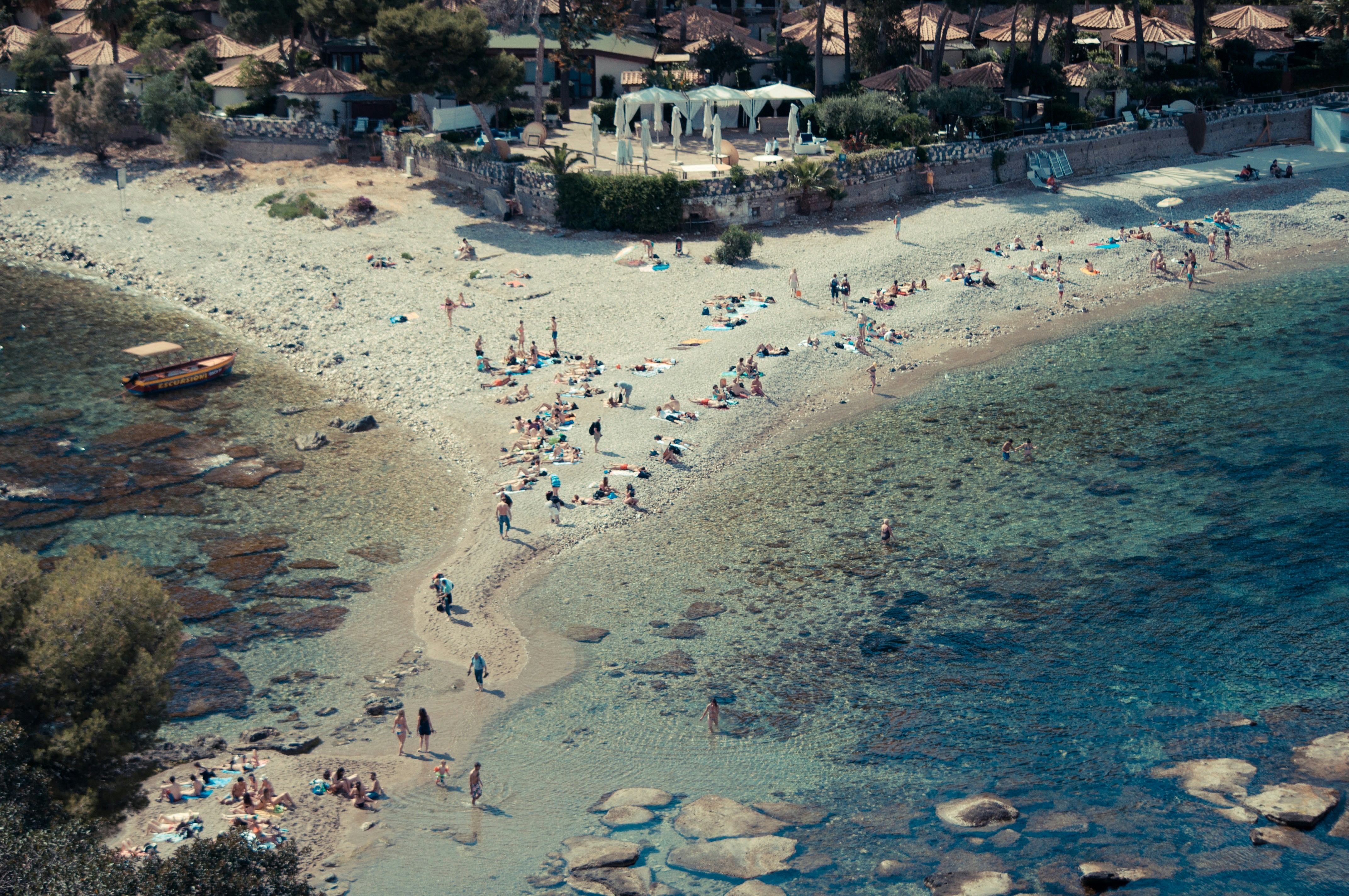 Sunlit Cove: A Pebble-Shoreline With Distant Terrace and Turquoise Waters