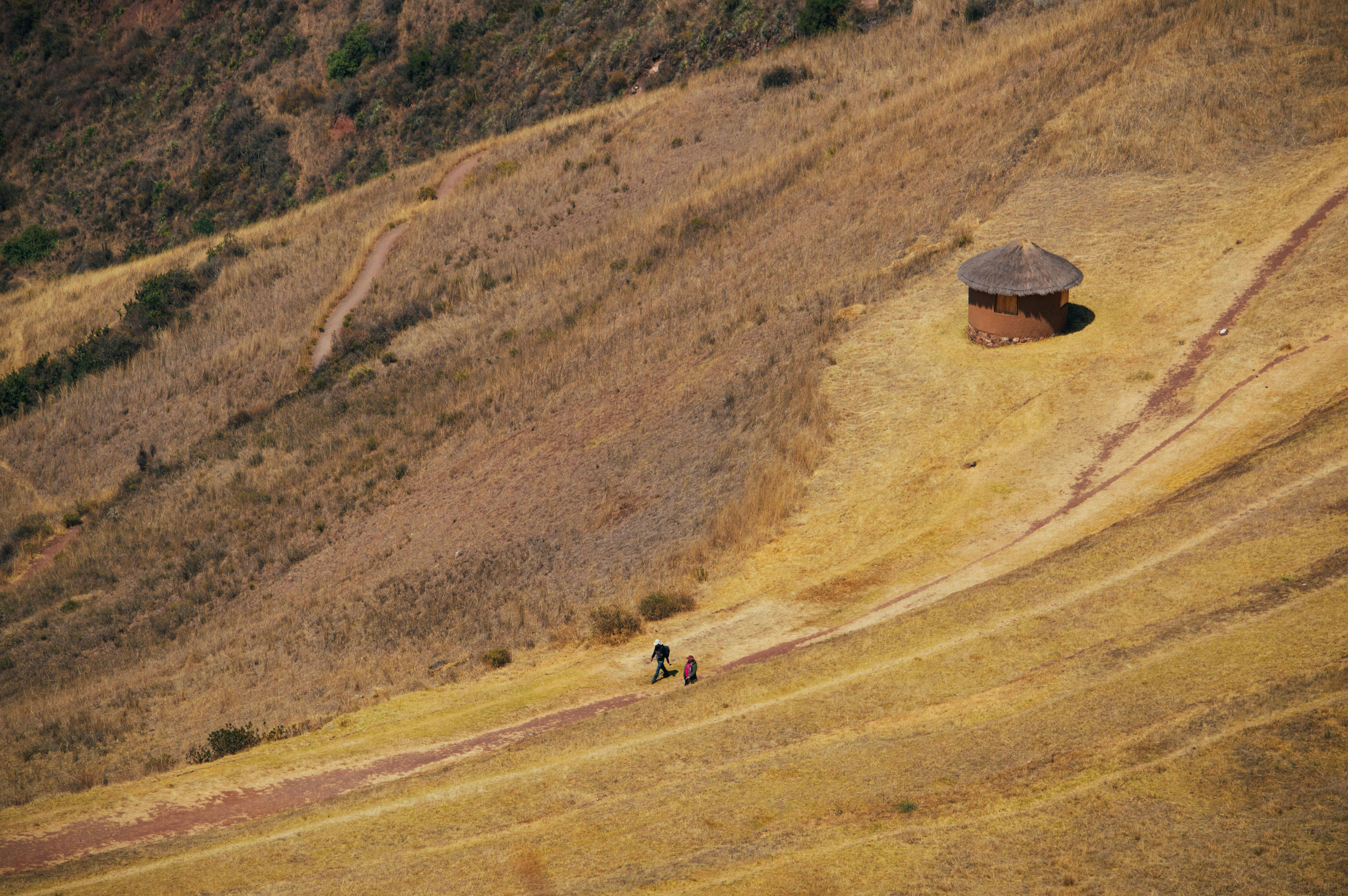 Gentle Hillside Pathway: Travelers Near the Hut Beneath Autumn Glow