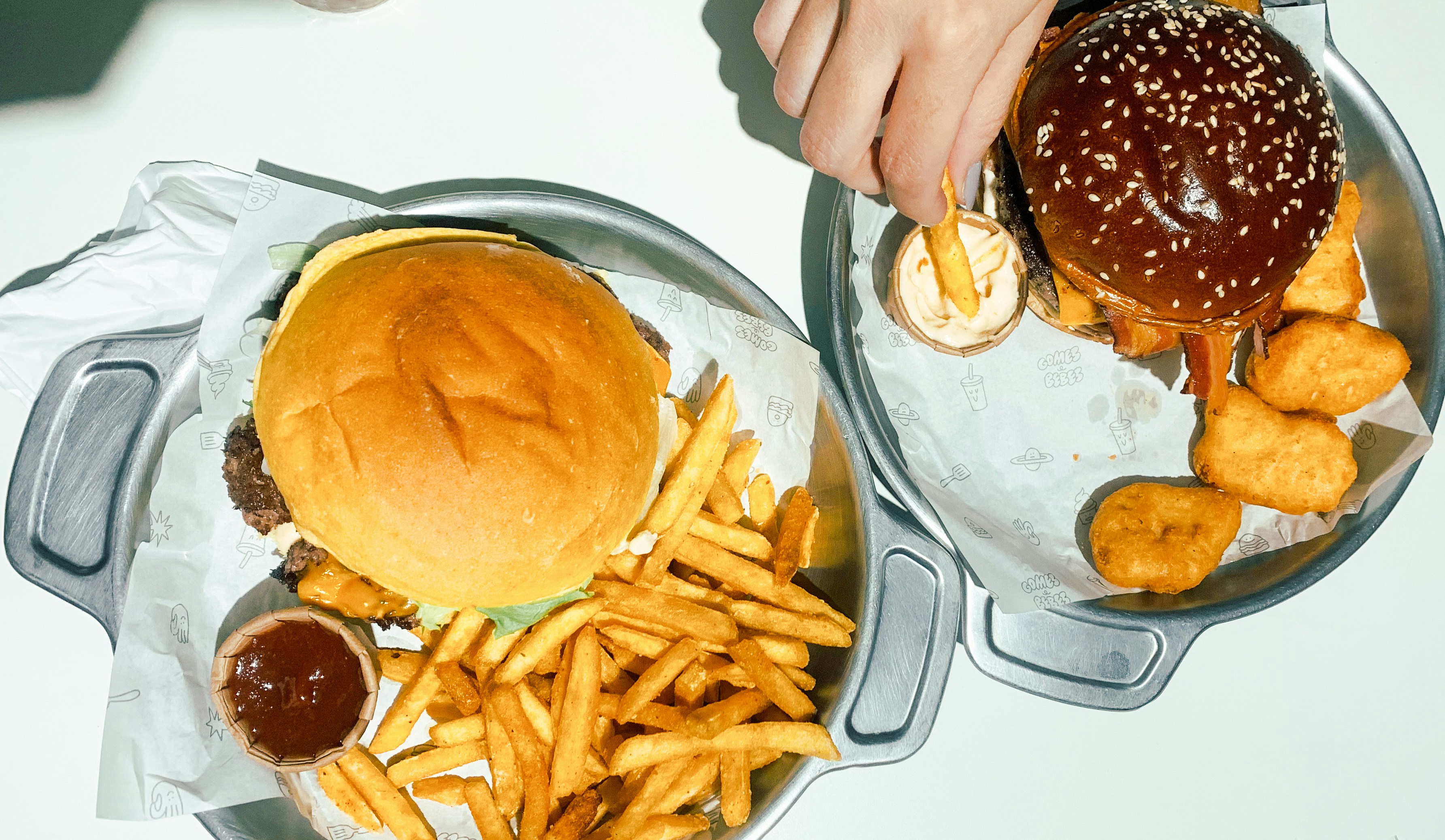 Two Lively Bites: Fries, Burgers, and Hand in Between