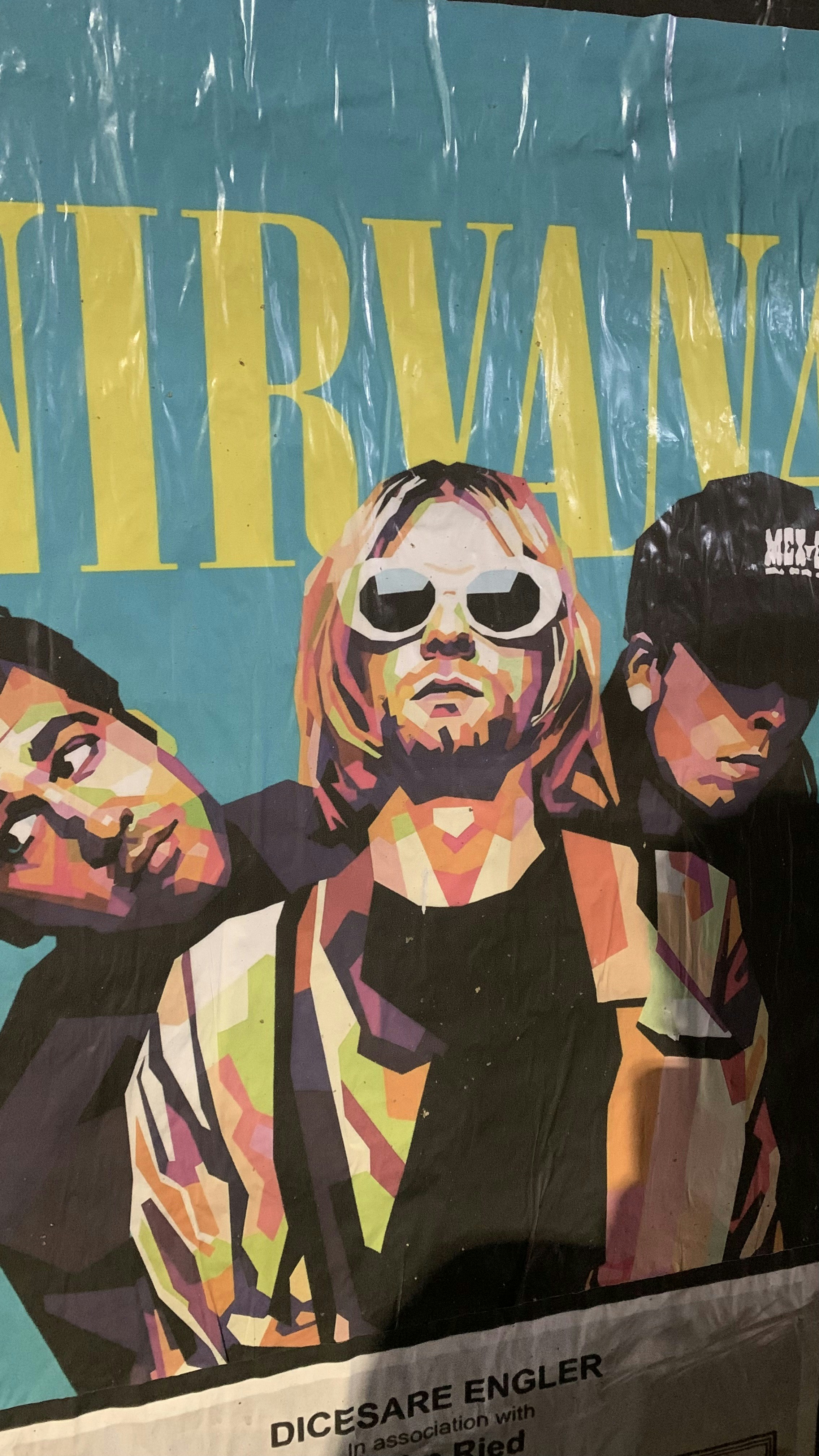 Bright pop-art poster featuring band members with oversized sunglasses and vibrant geometric tones. Poster-like artwork with bold typography at the top and a credit line at the bottom.