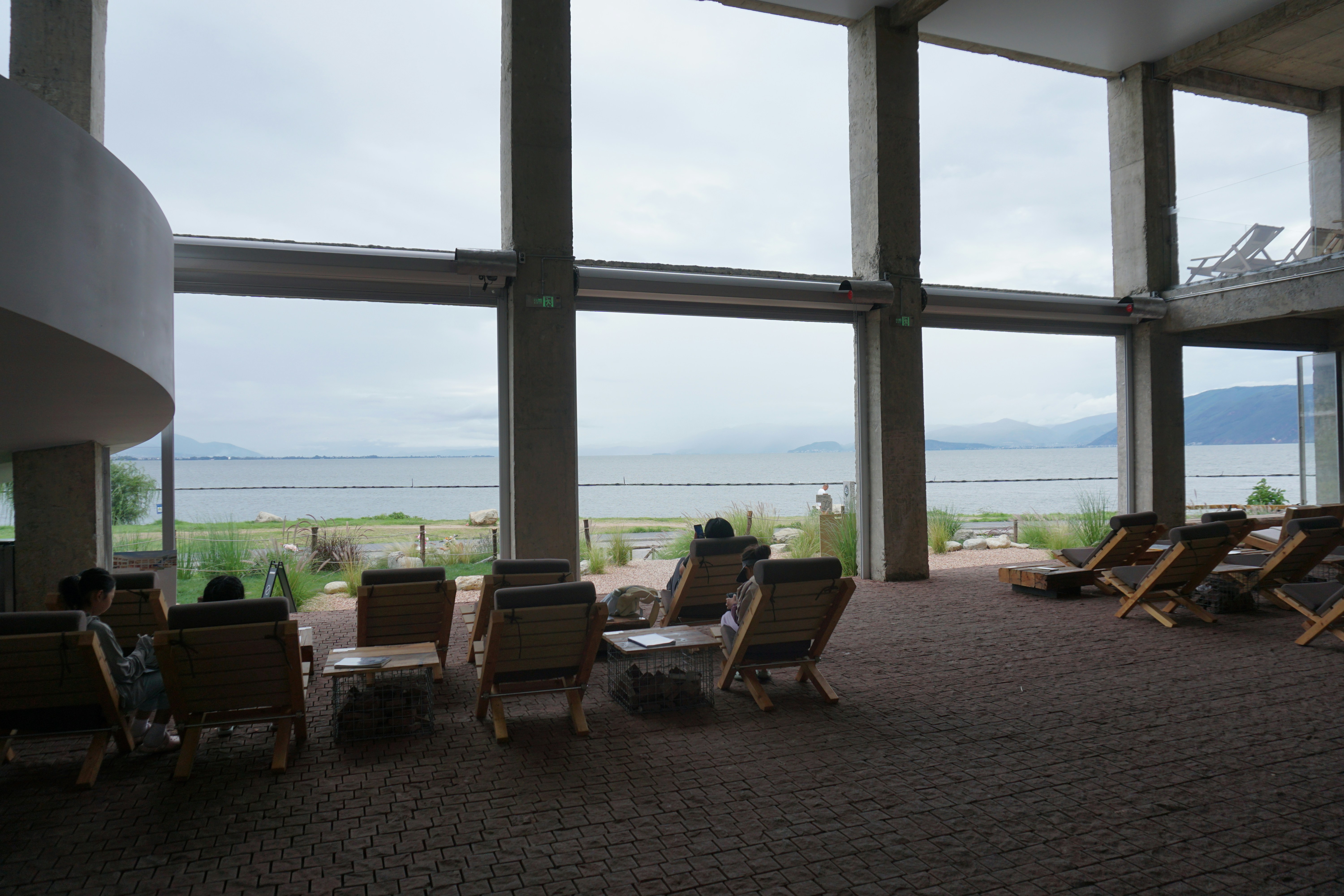 Shaded Deckscape: loungers facing calm sea under a concrete frame