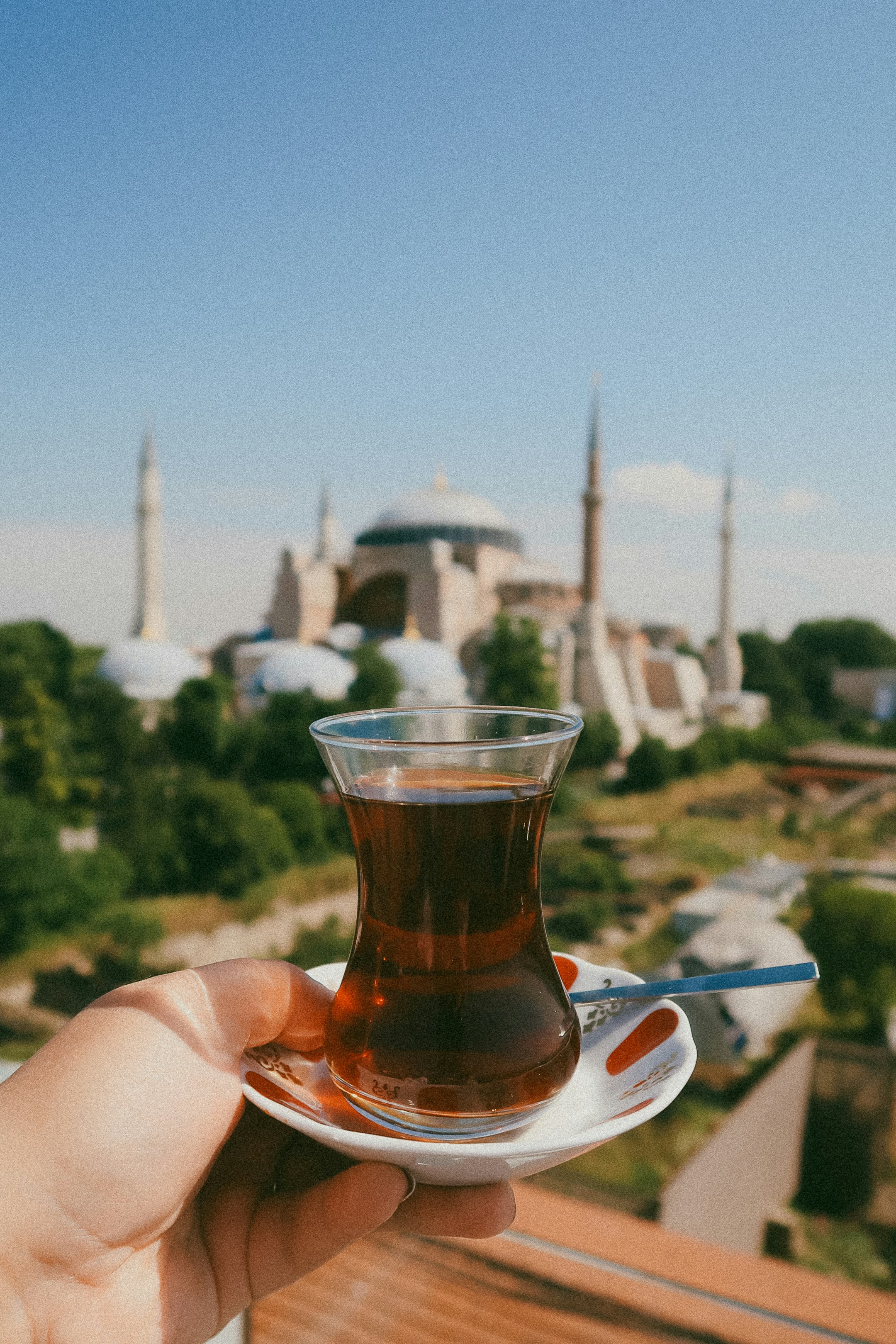 Tea in Focus: Turkish Skyline with a Glass in Hand