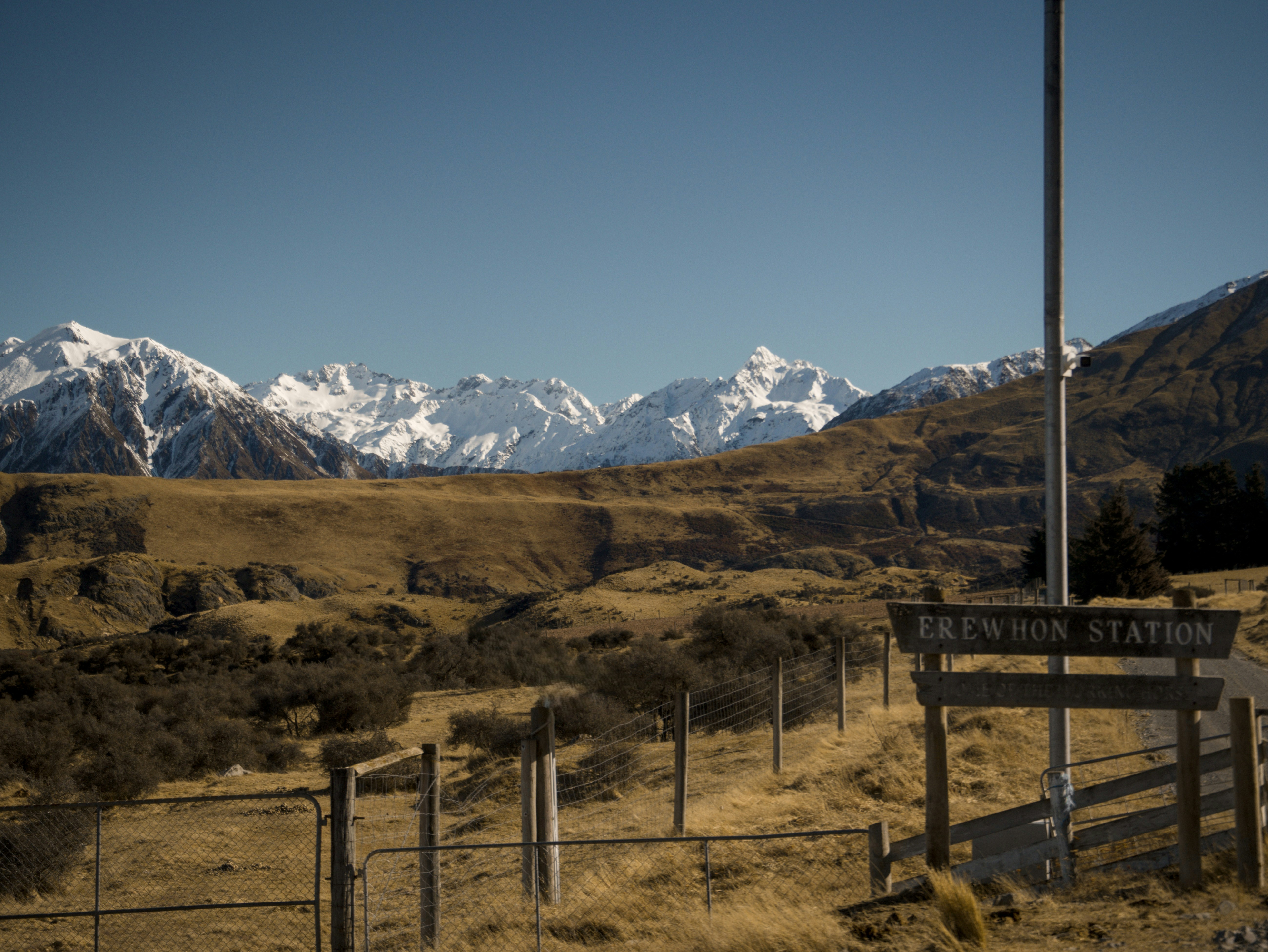 Fence and Signpost Framing the Snow-Capped Range