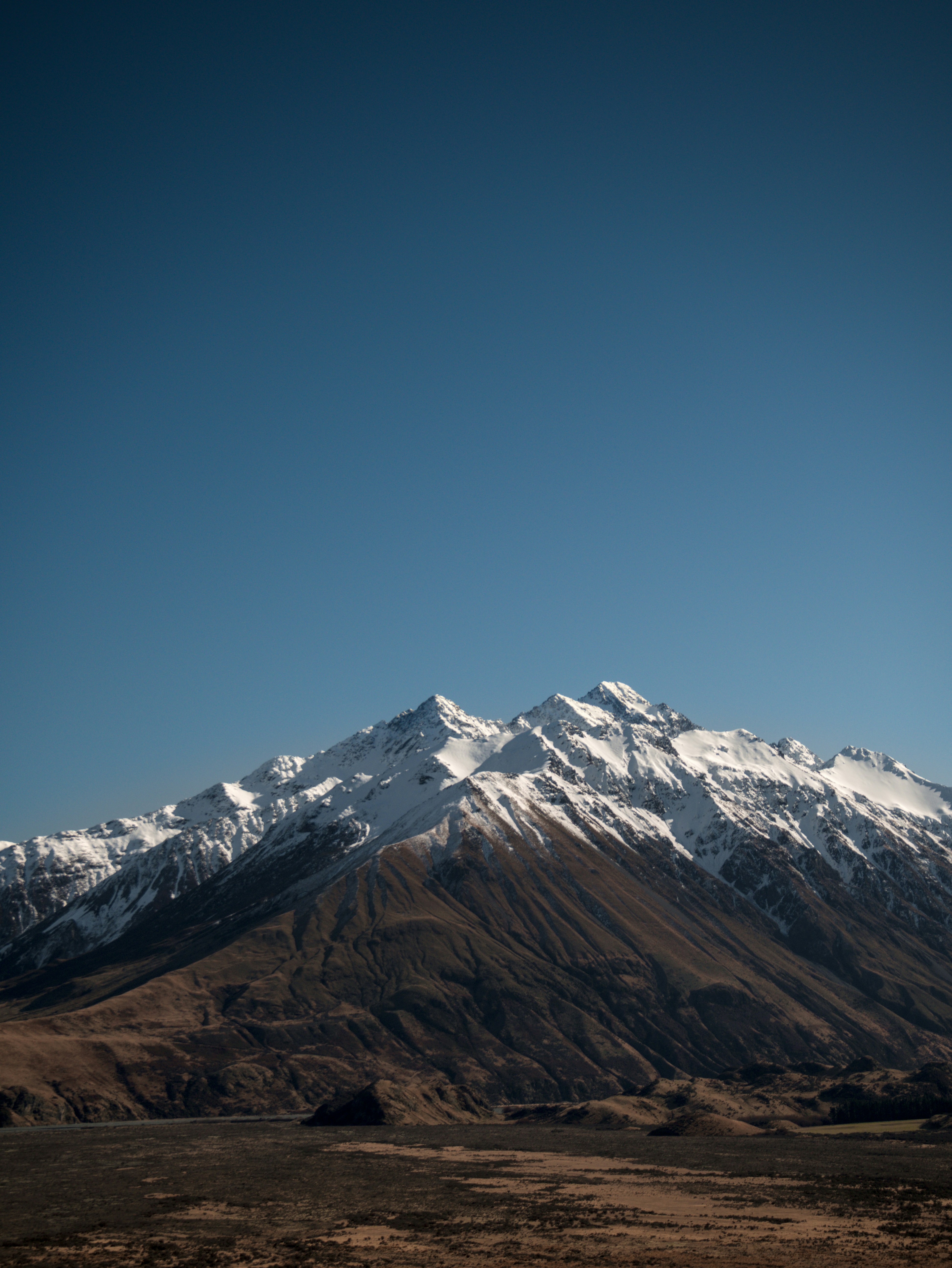 Snow-Crowned Peaks Beneath a Wide, Clear Sky