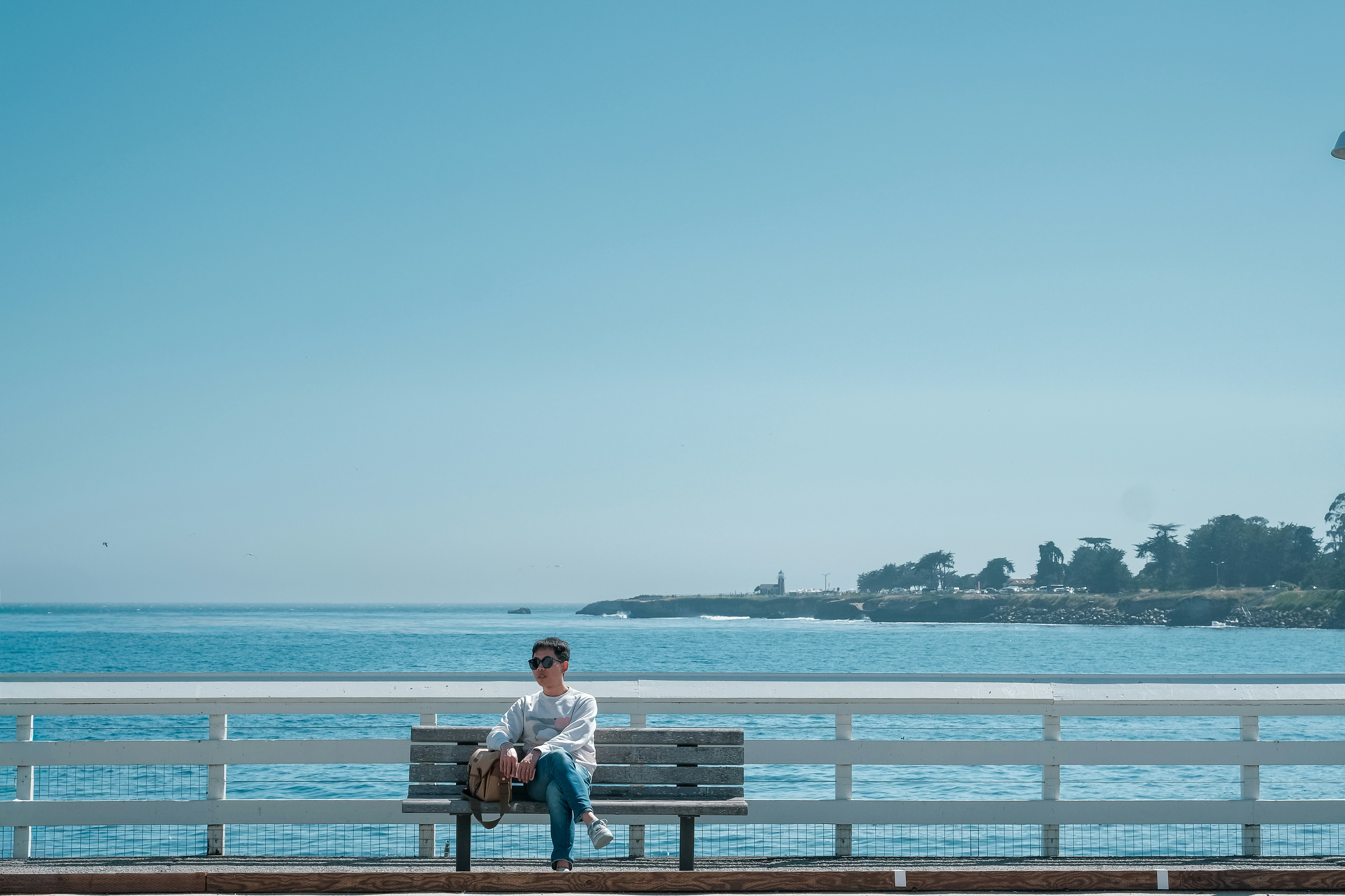 Solitary Pause on the Pier: A Quiet Moment by the Sea
