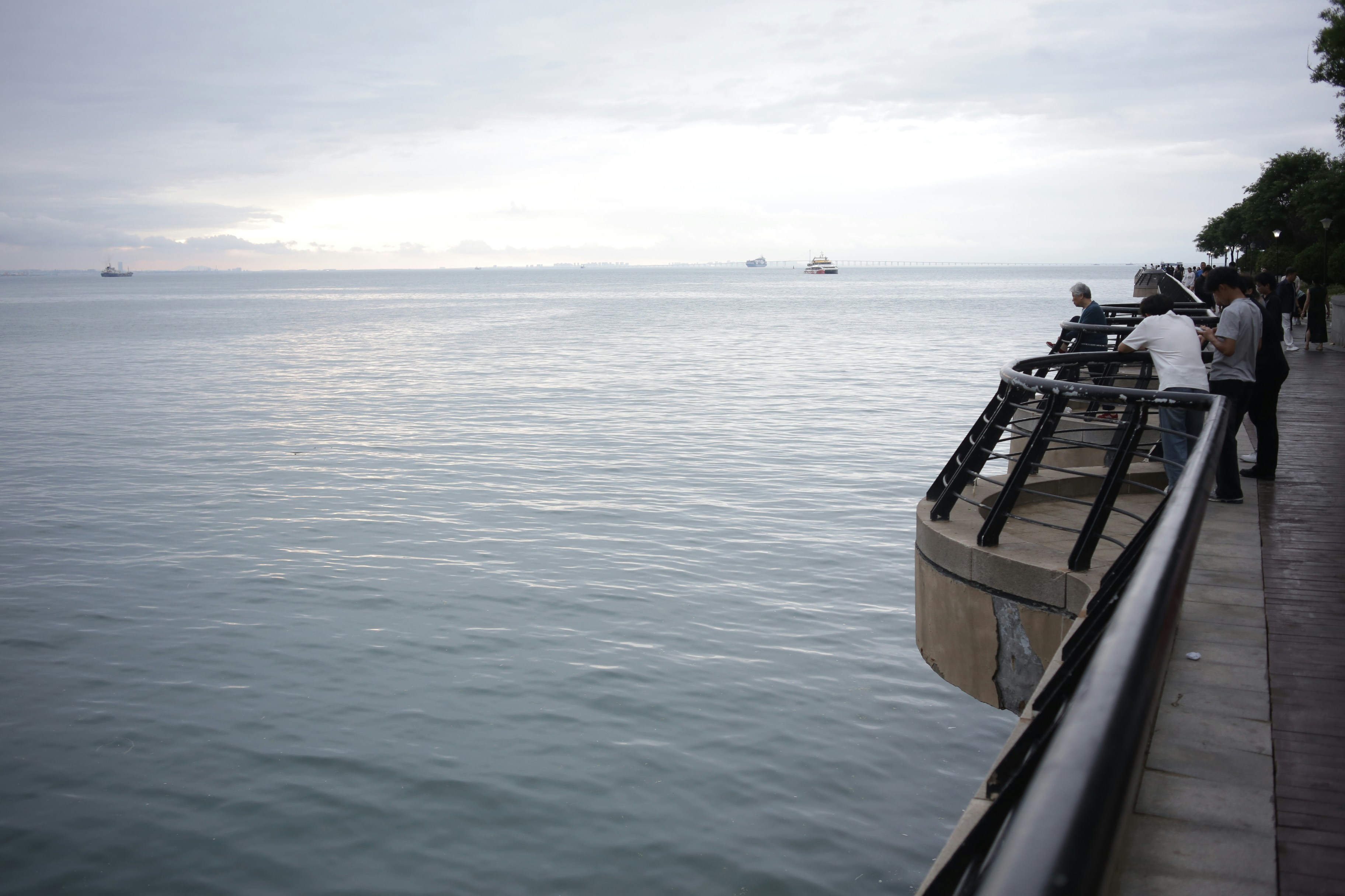Rim and Rail: Evening Promenade Along the Calm Sea